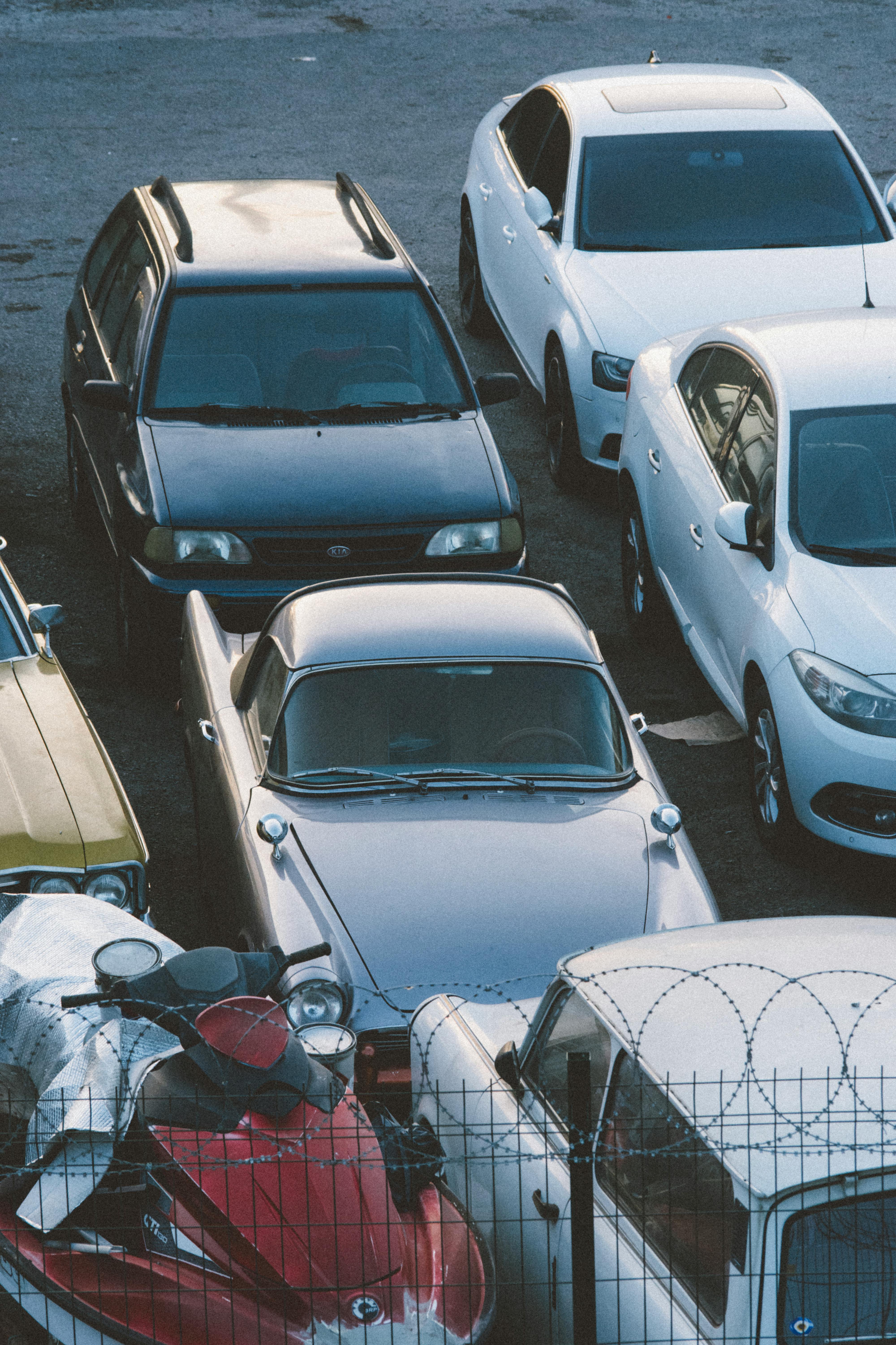 Classic Car Among Modern Cars in a Parking Lot Fenced with Barbed Wire ...