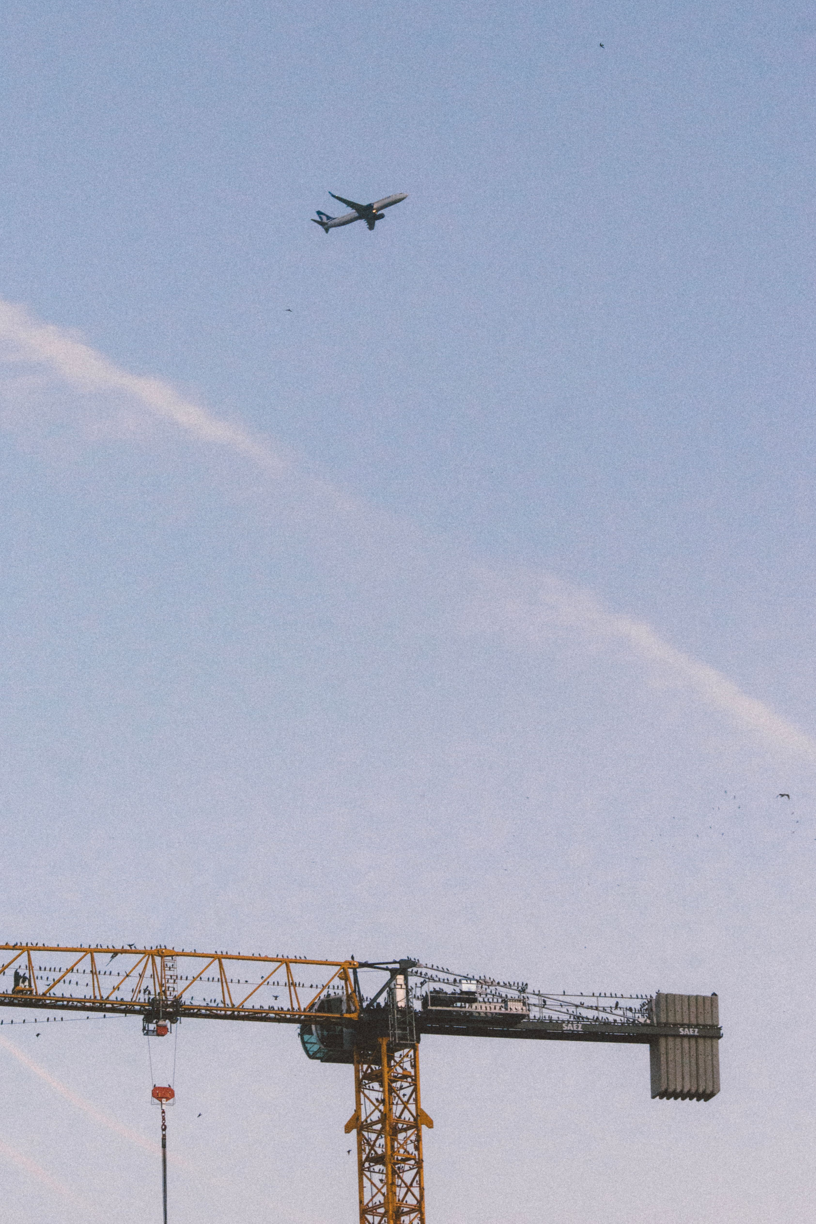 Aircraft Flying over Crane · Free Stock Photo