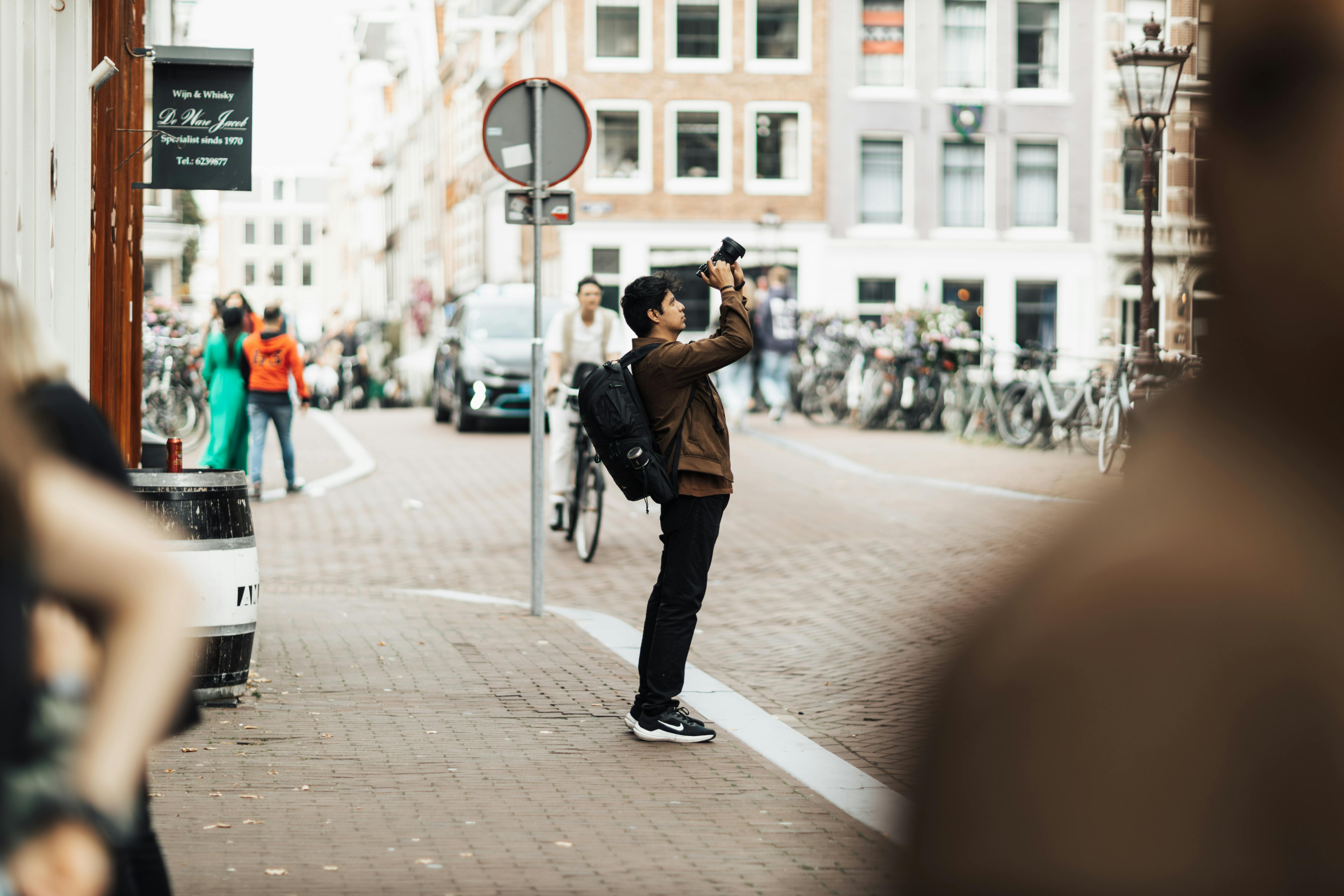 Person Holding a Smart Phone and Photographing People Walking on the ...