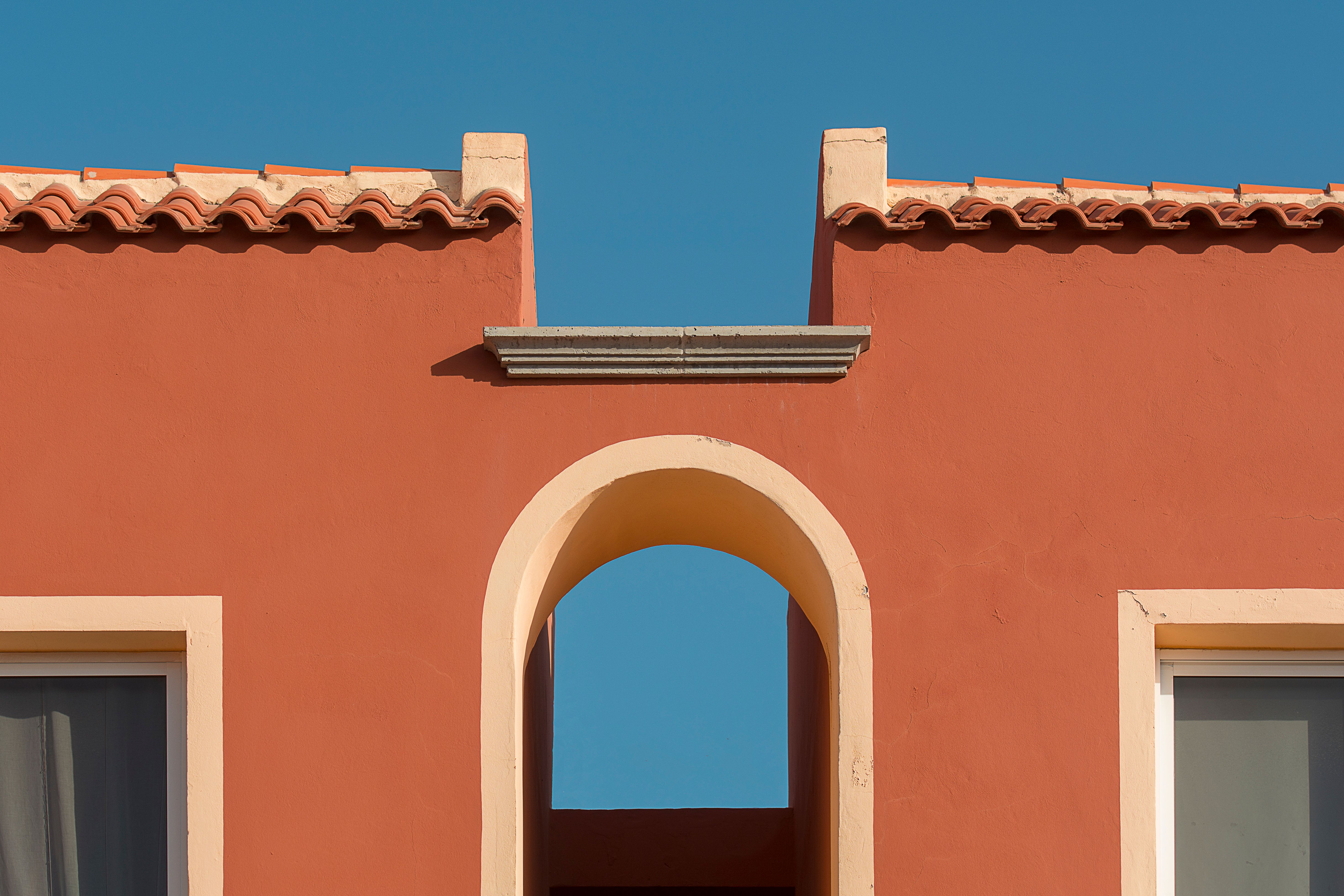 Gap between Roofs atop Red Building · Free Stock Photo