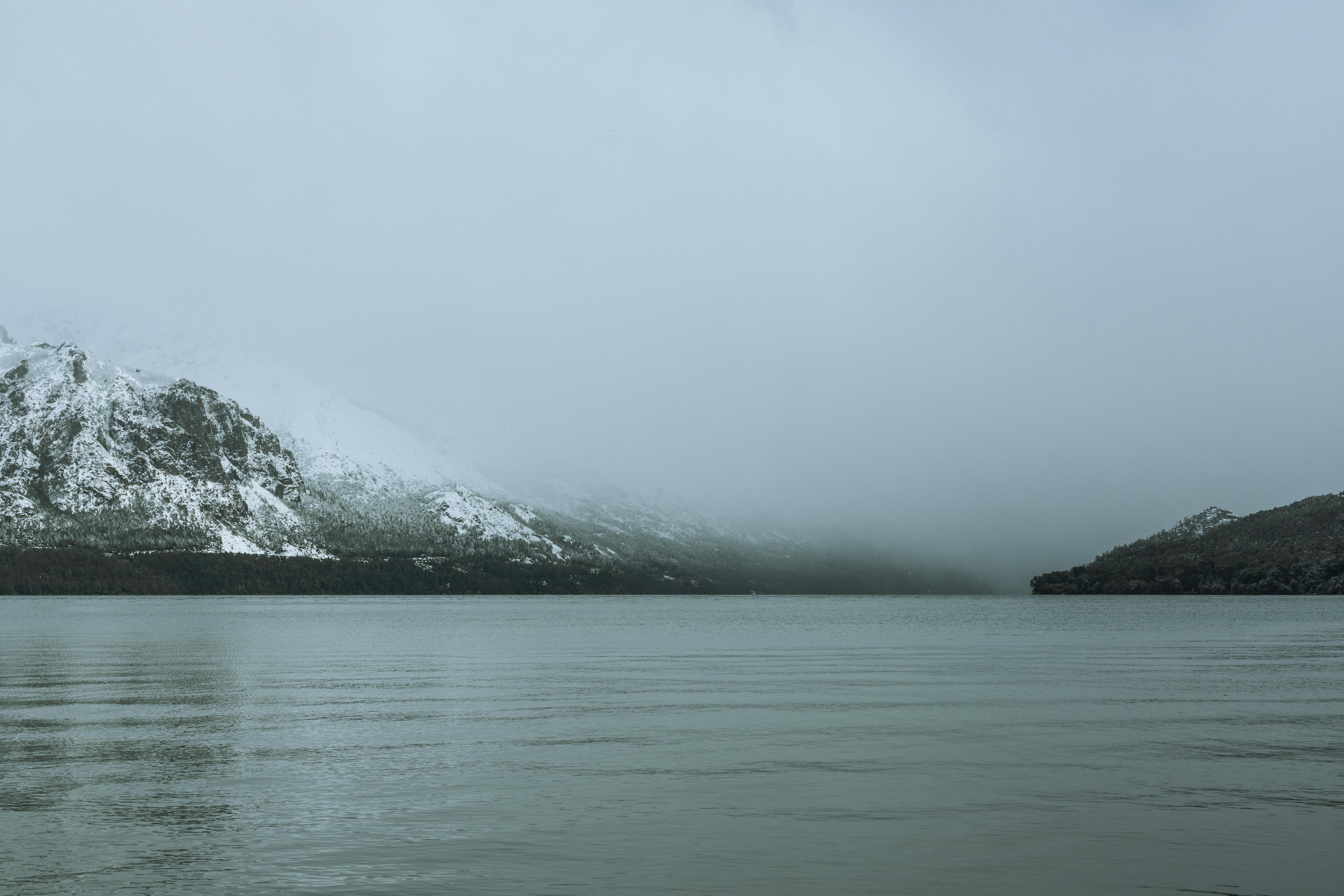 Fog over Lake with Hills in Snow behind · Free Stock Photo