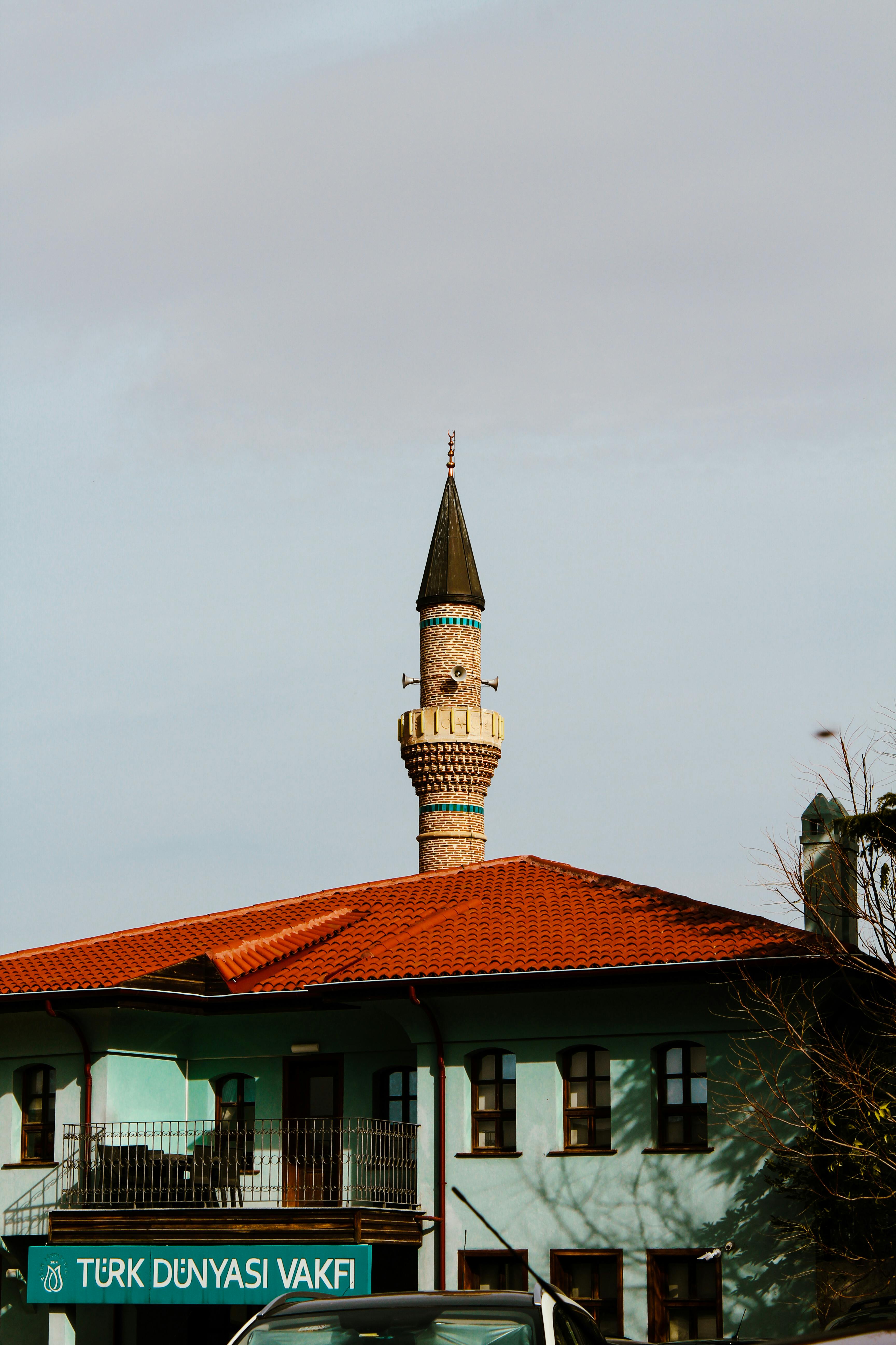 Traditional Minaret Tower in Distance Above a Building in Turkey · Free Stock Photo