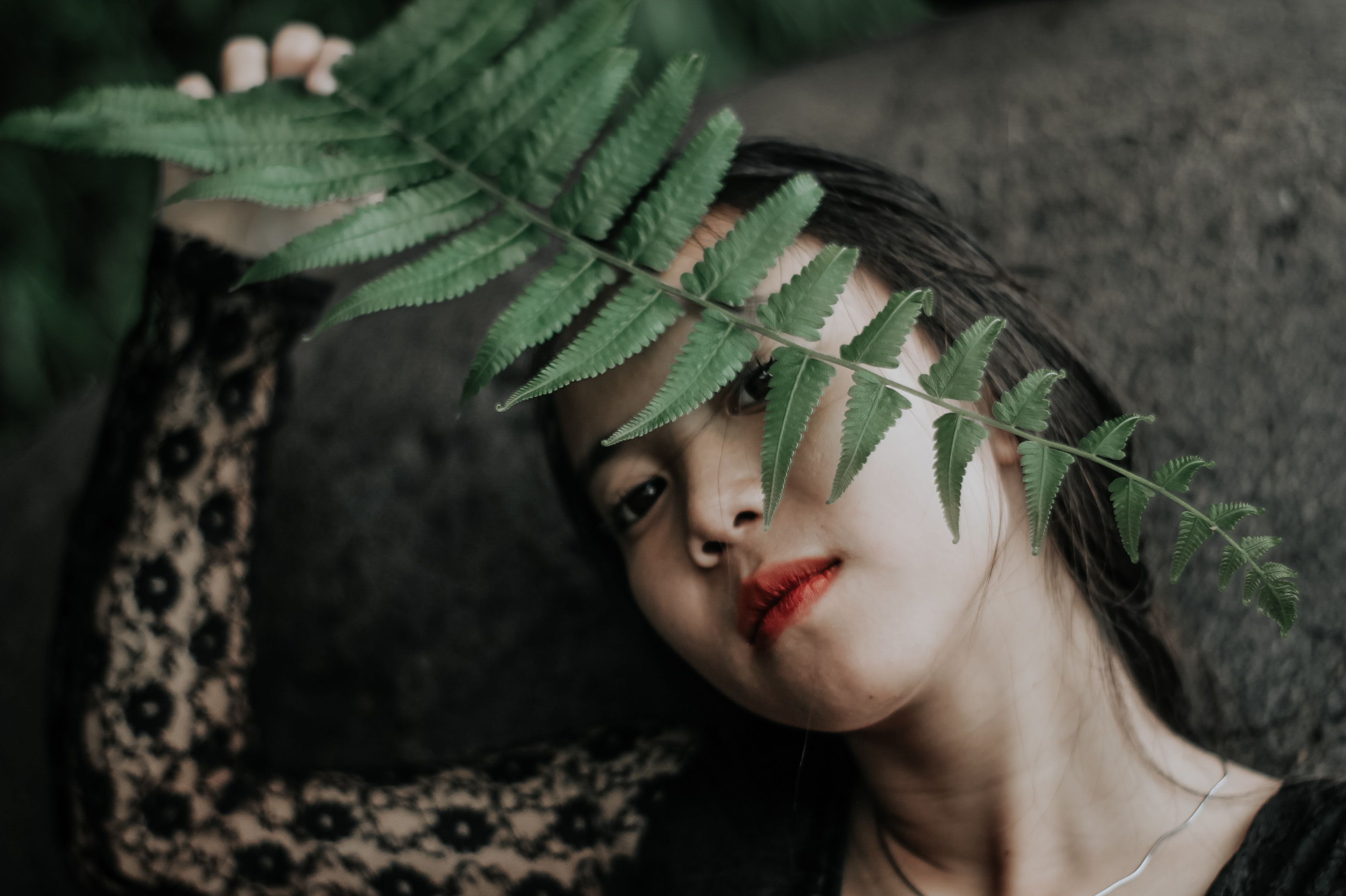 Young Woman Holding a Fern Leaf Above Her Head · Free Stock Photo