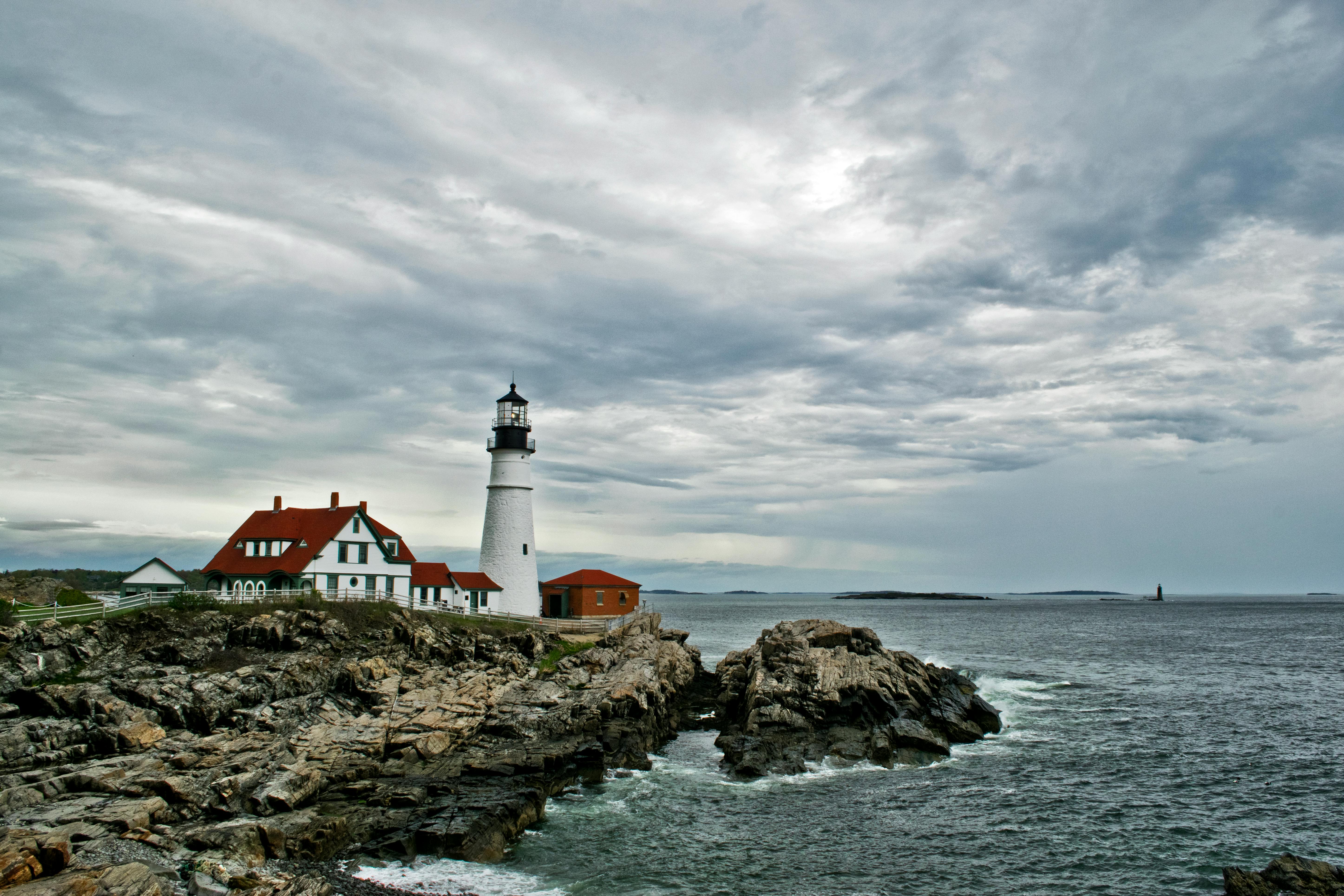 Red and White Lighthouse on Land · Free Stock Photo