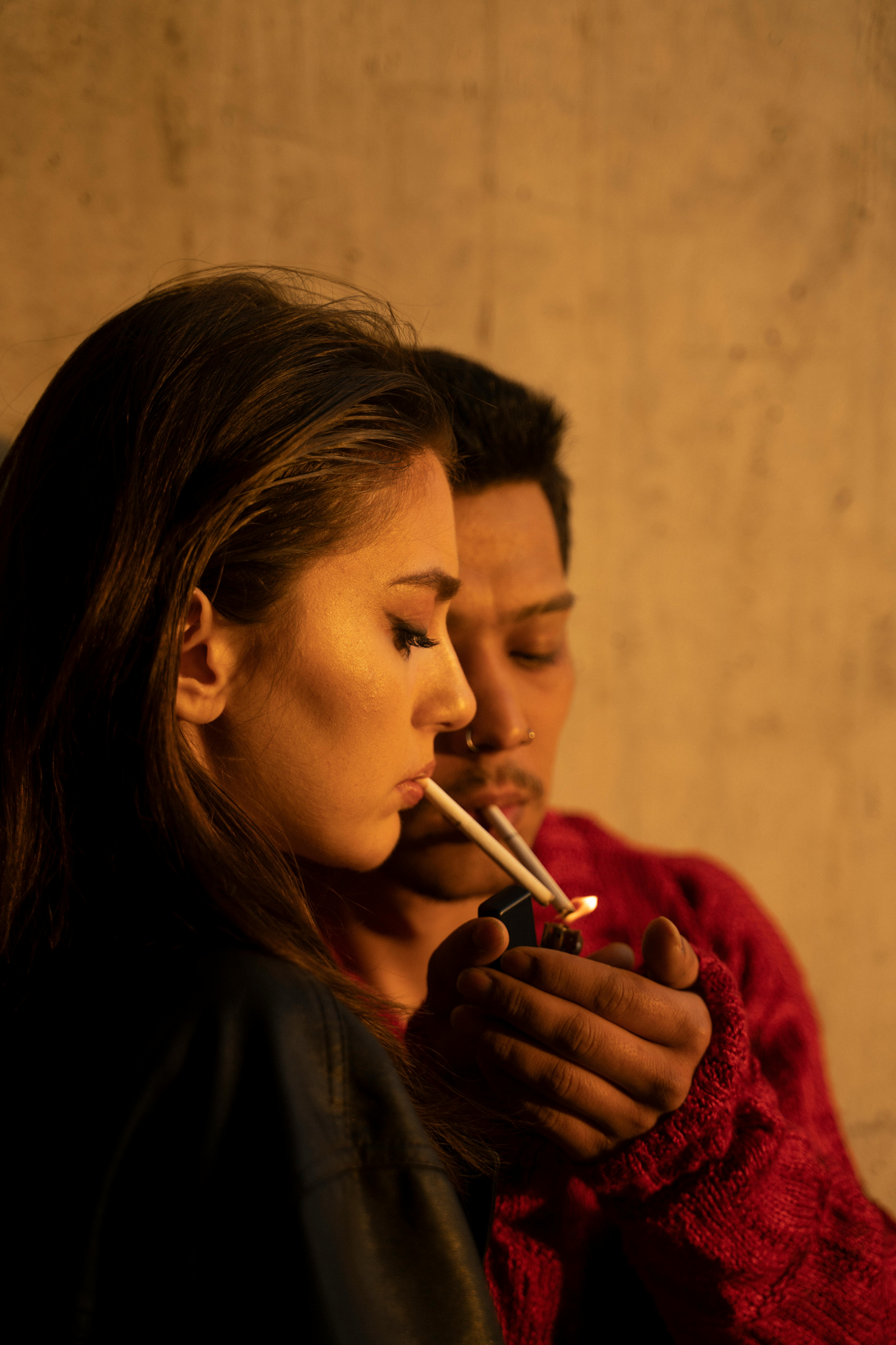 A man and woman smoking cigarettes together · Free Stock Photo