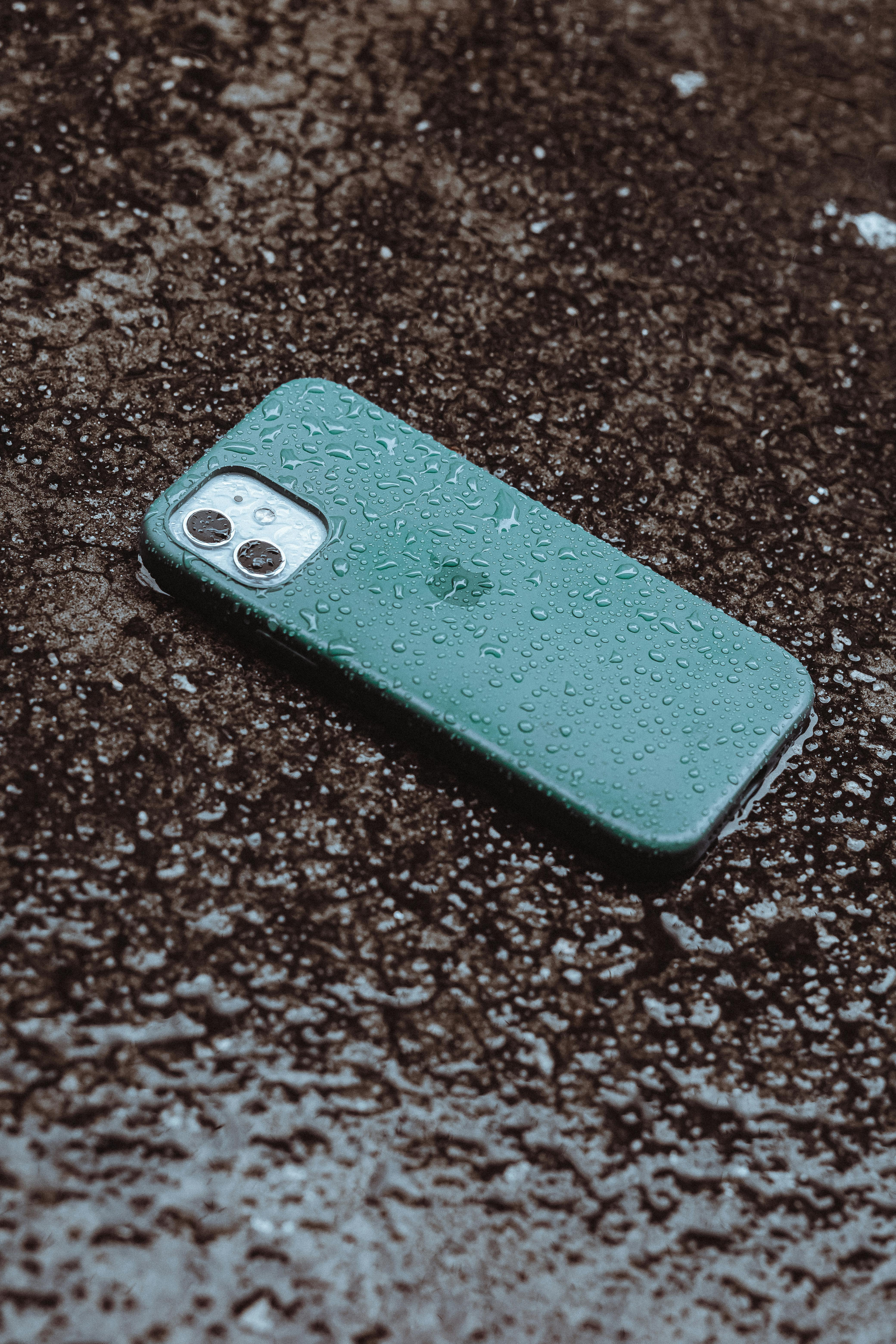 Raindrops on IPhone on Ground · Free Stock Photo