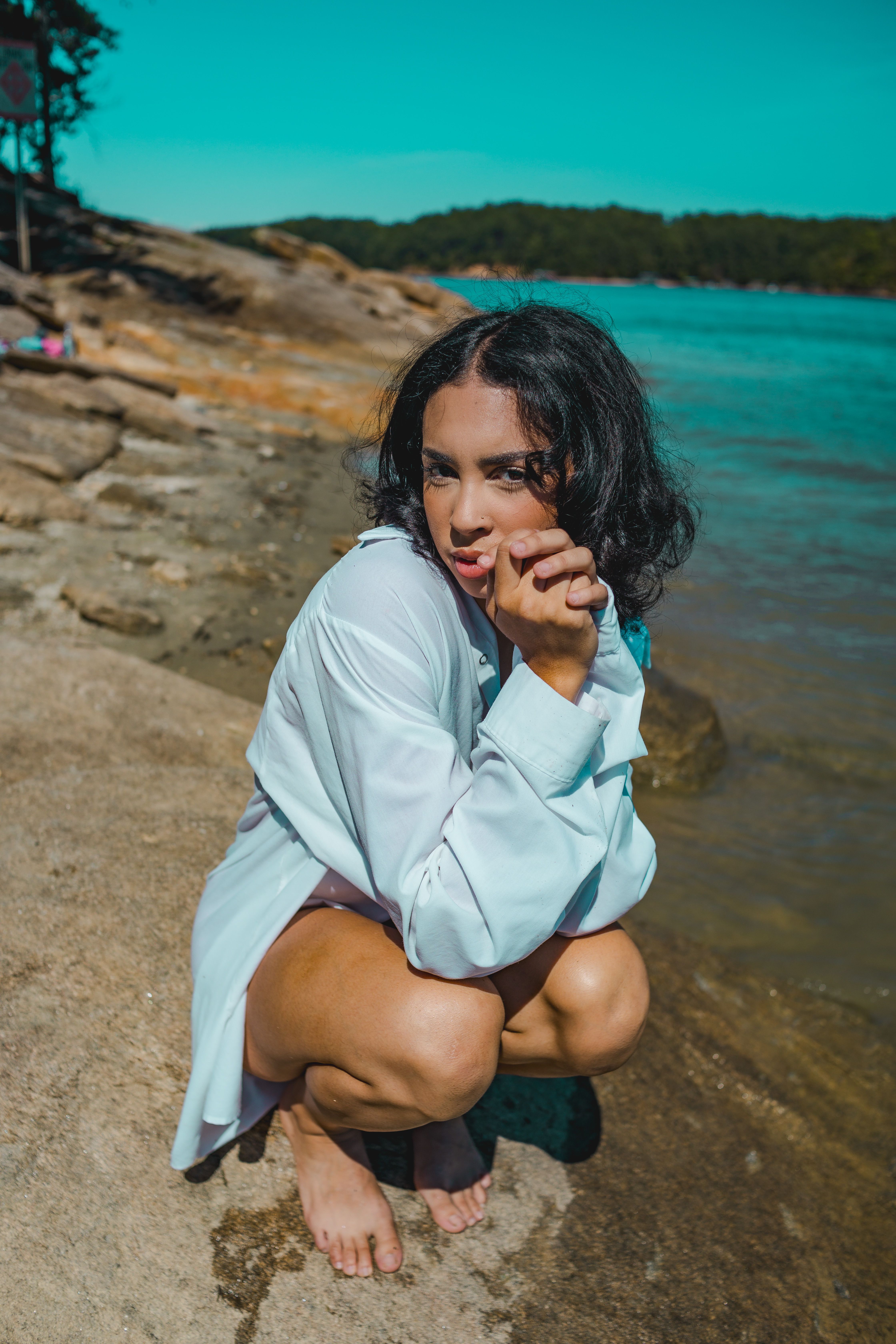 Woman Crouching by the Water · Free Stock Photo