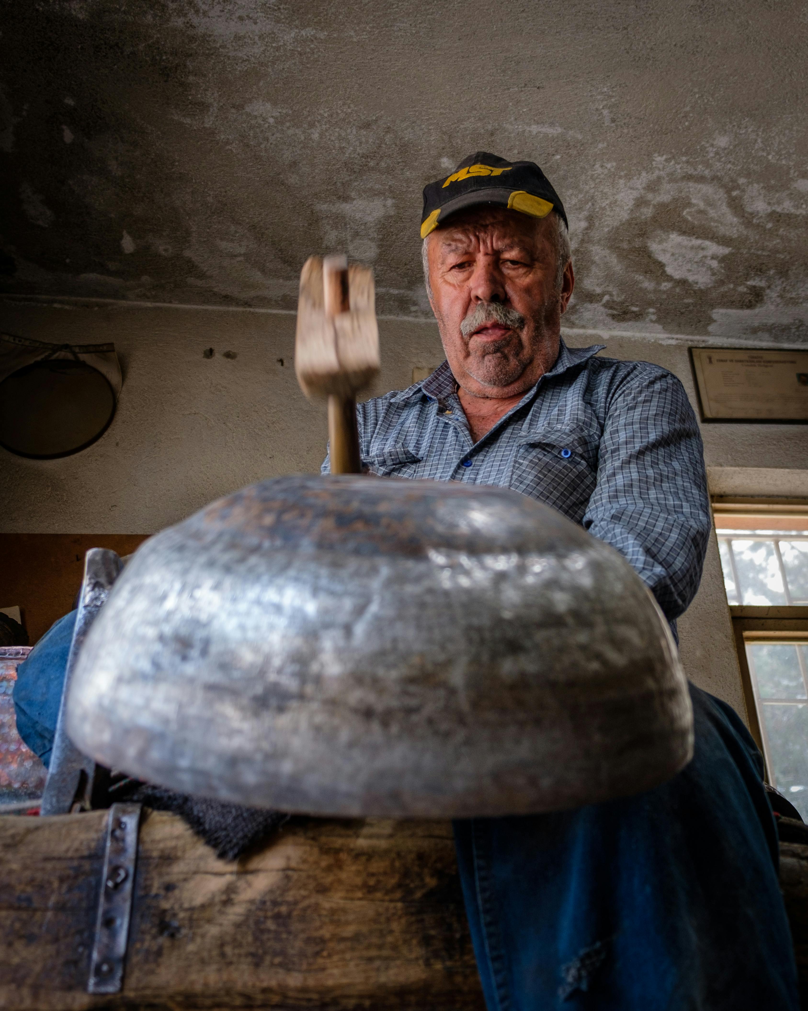Man Working with Hammer over Pot · Free Stock Photo