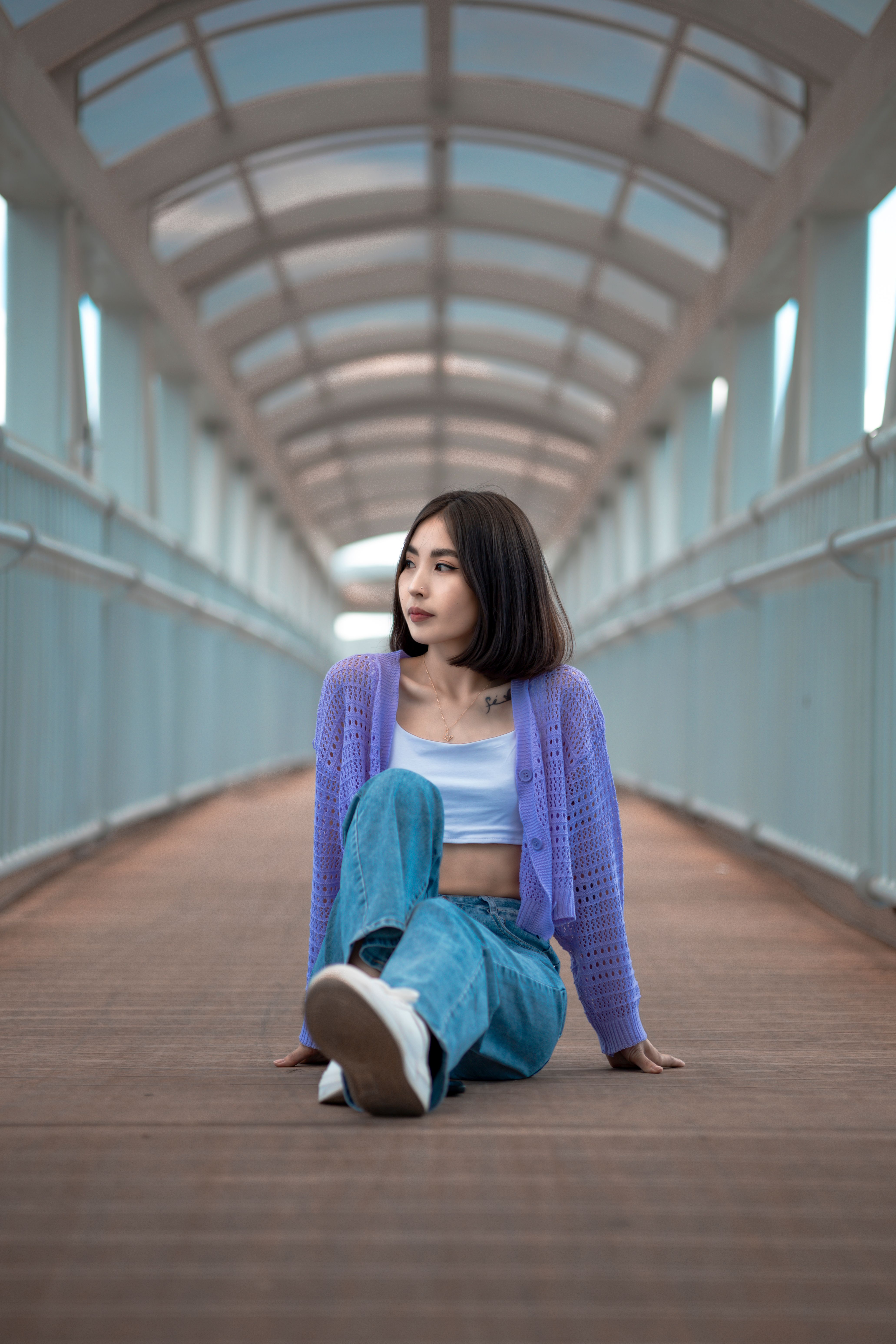 Girl Wearing a Cardigan and Jeans, Sitting on the Footbridge Floor ...