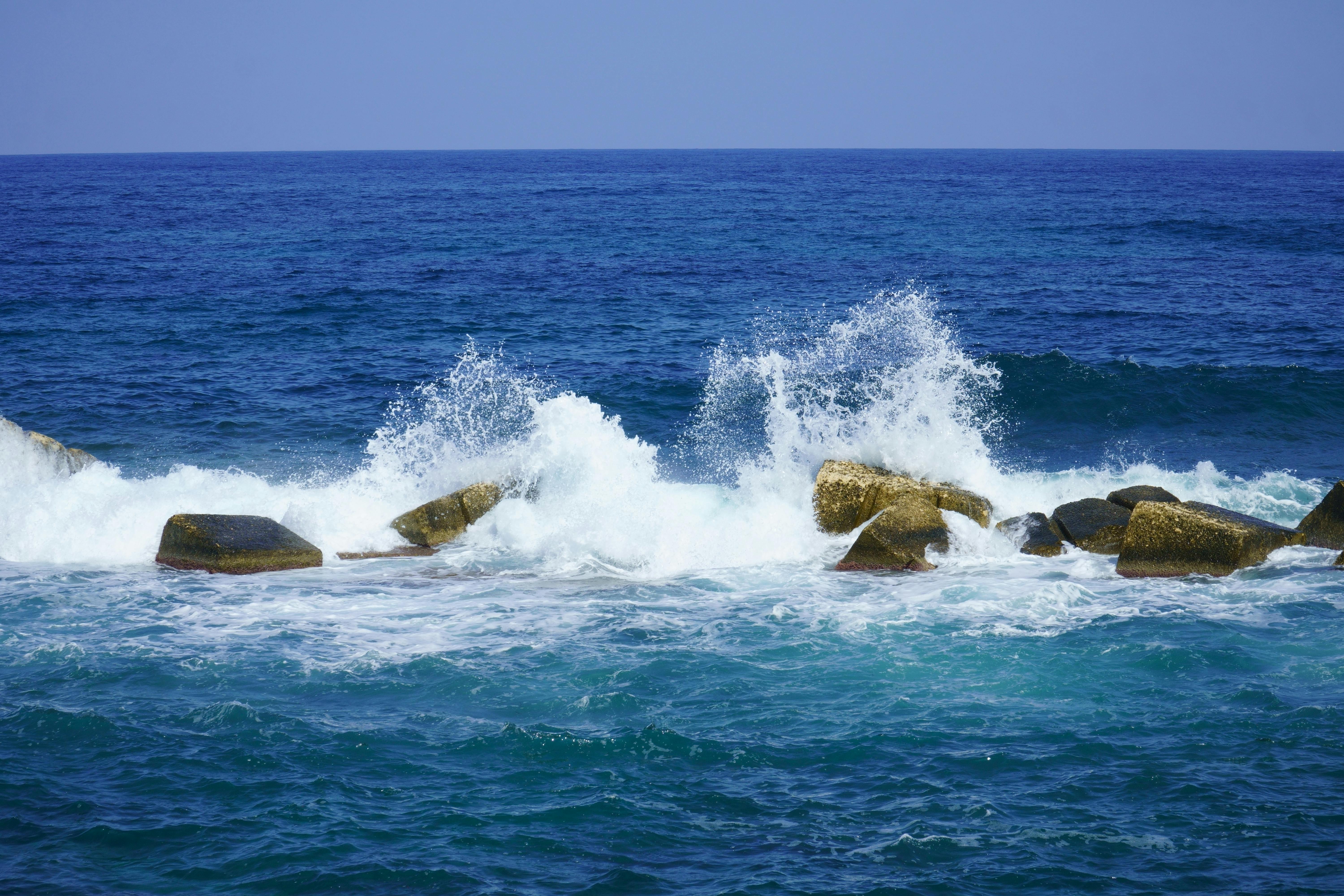 Seashore With Rocks Under Blue Sky · Free Stock Photo