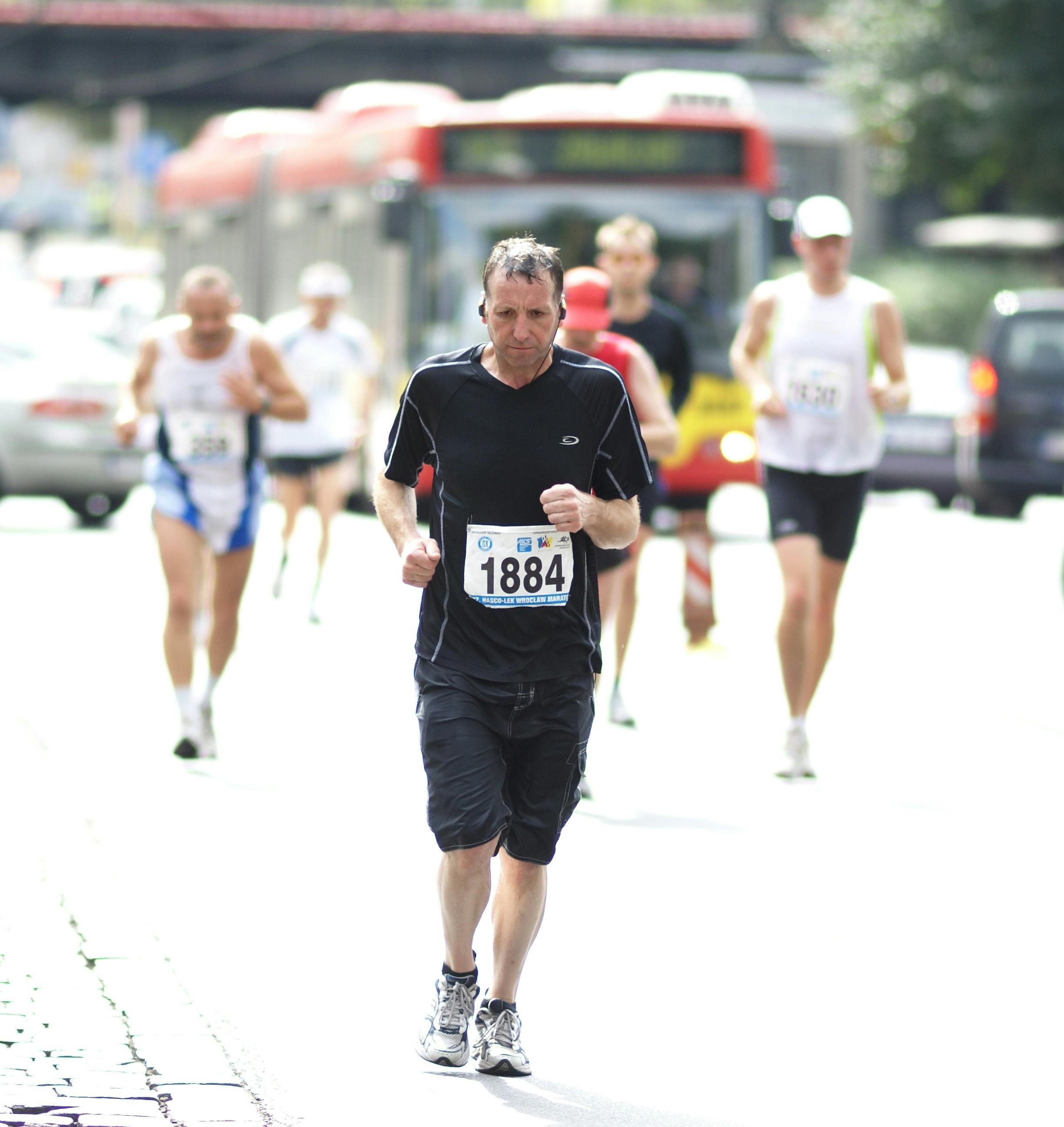 A man running in a marathon with other runners · Free Stock Photo