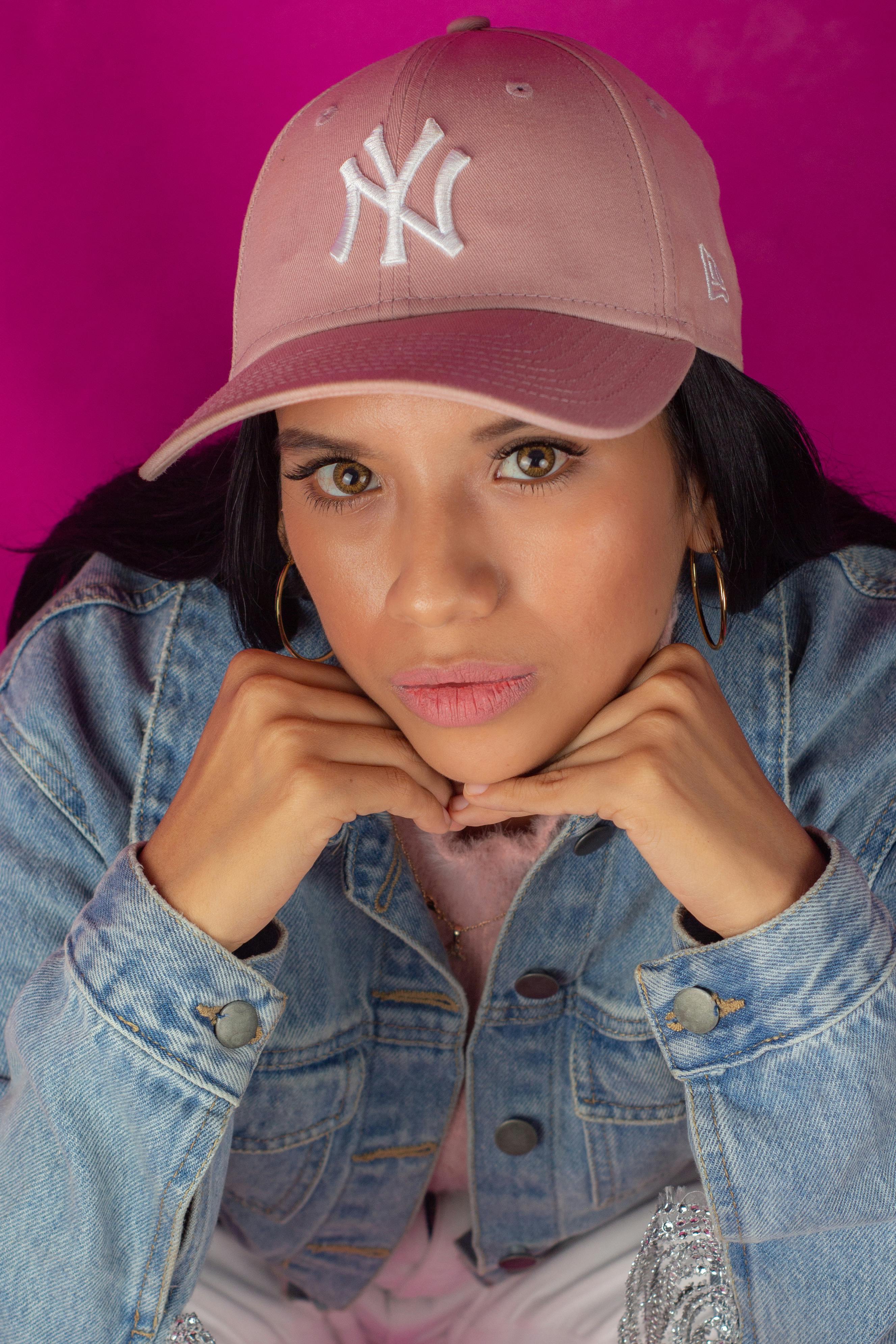 Serious female model in trendy cap in studio · Free Stock Photo