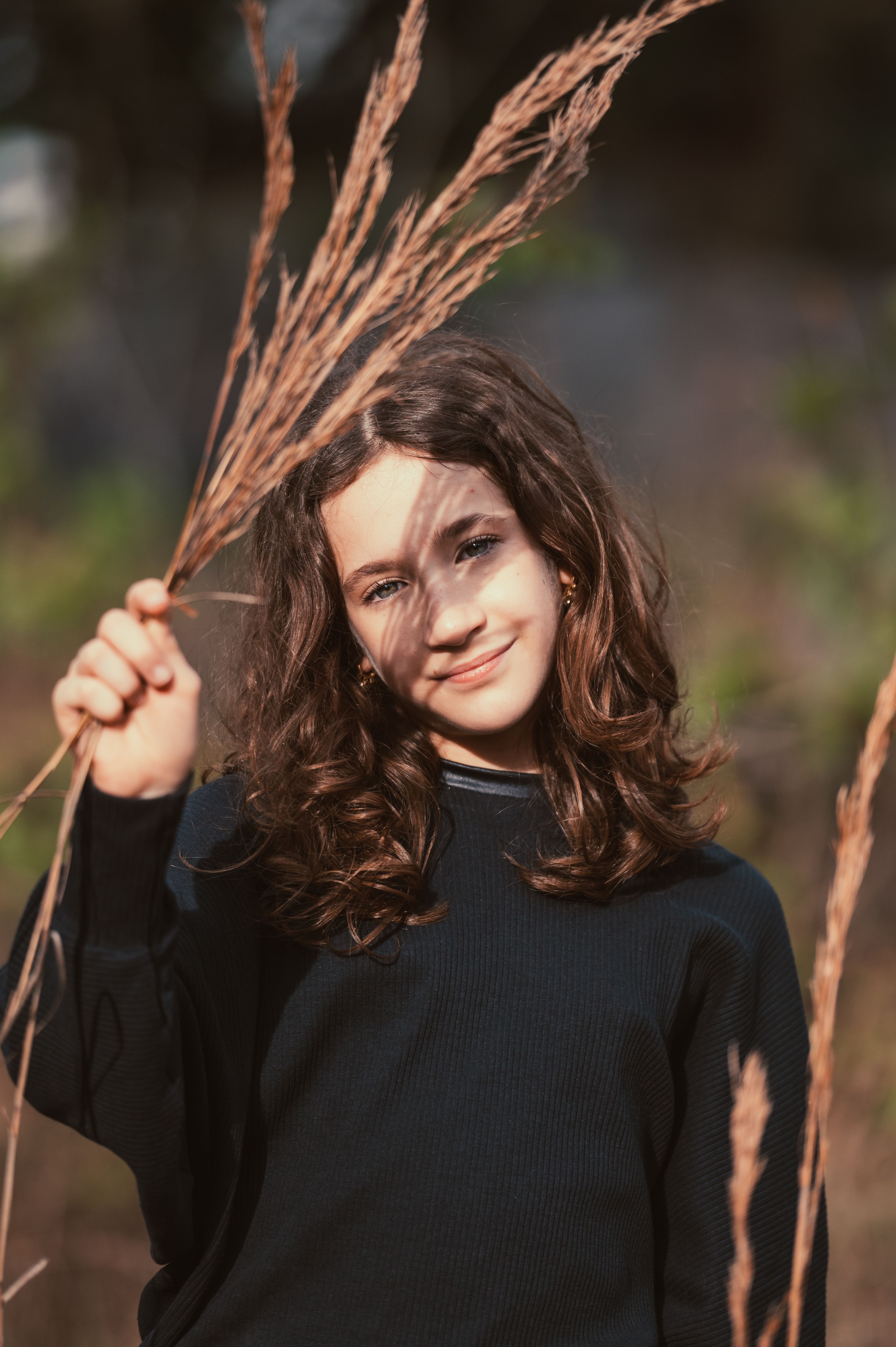 Smiling Girl Posing with Spikes in Field on Sunset · Free Stock Photo