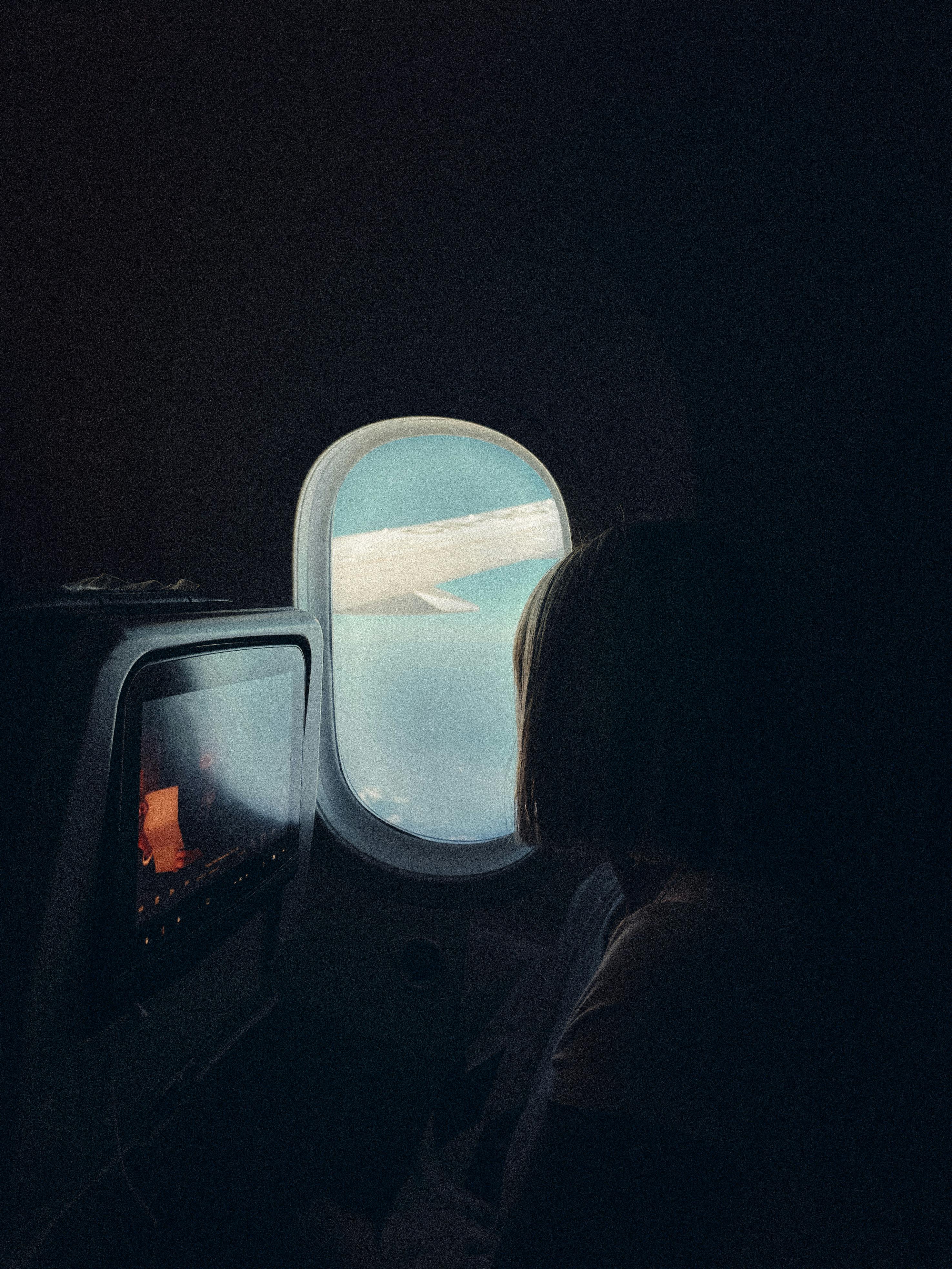 Woman Looking through Airplane Window · Free Stock Photo
