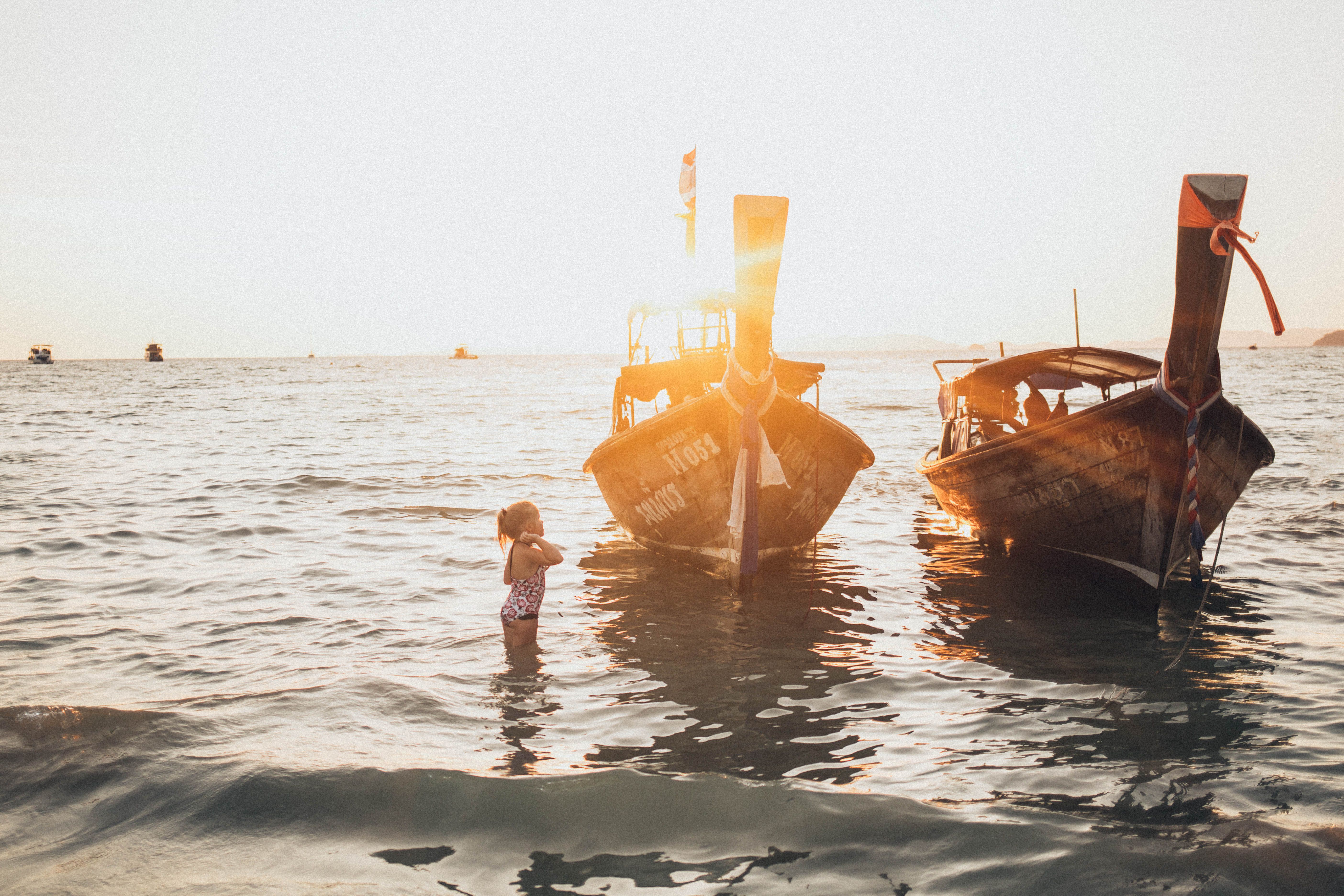 Girl In Body Of Water Near Boat · Free Stock Photo