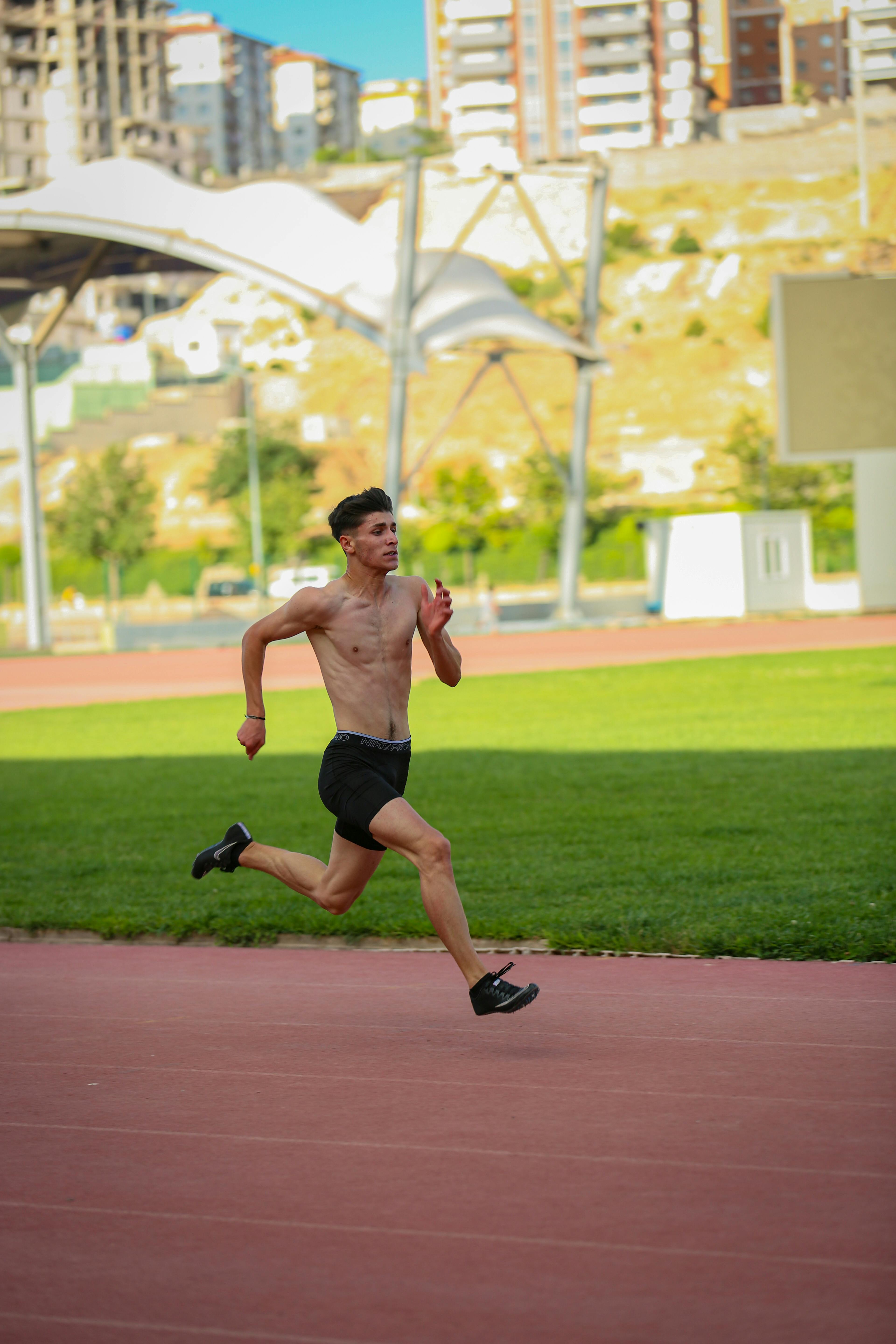 Shirtless Man Running on Track · Free Stock Photo