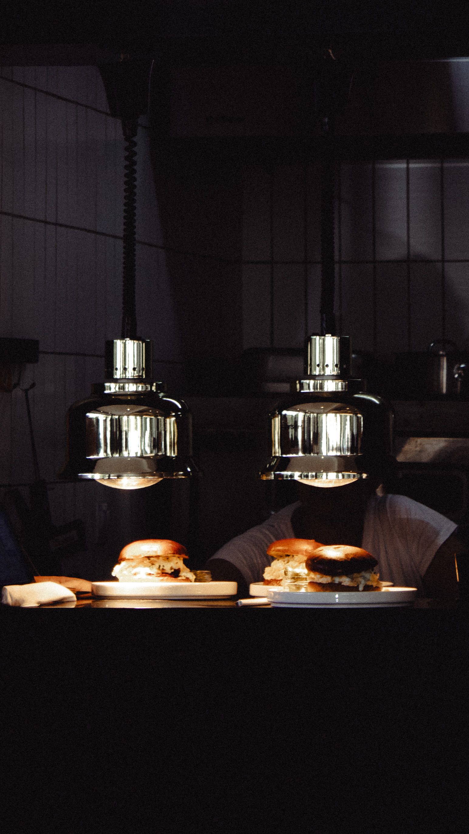 Lamps Hanging over Burgers on Table · Free Stock Photo