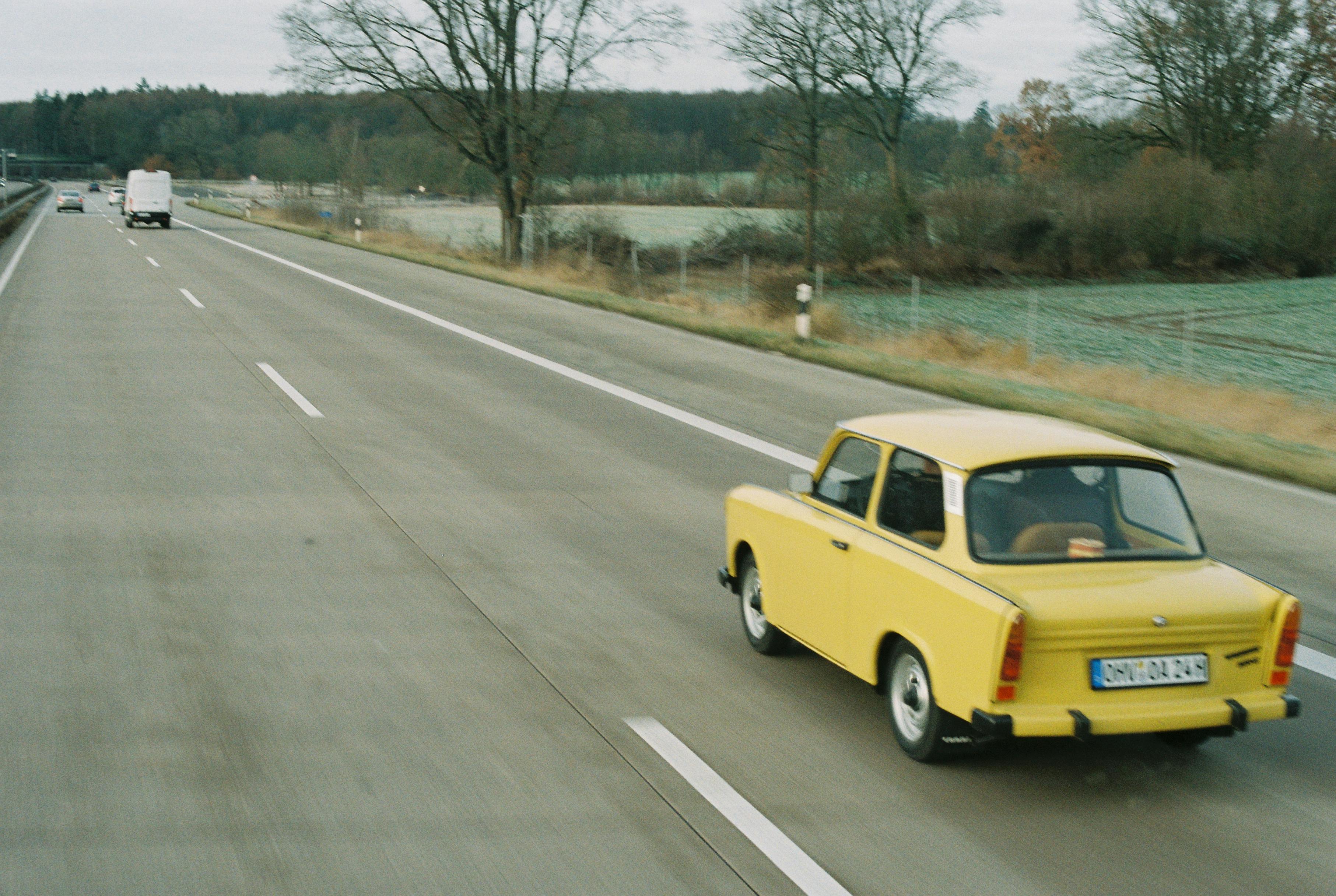 Yellow Trabant Running on Highway · Free Stock Photo