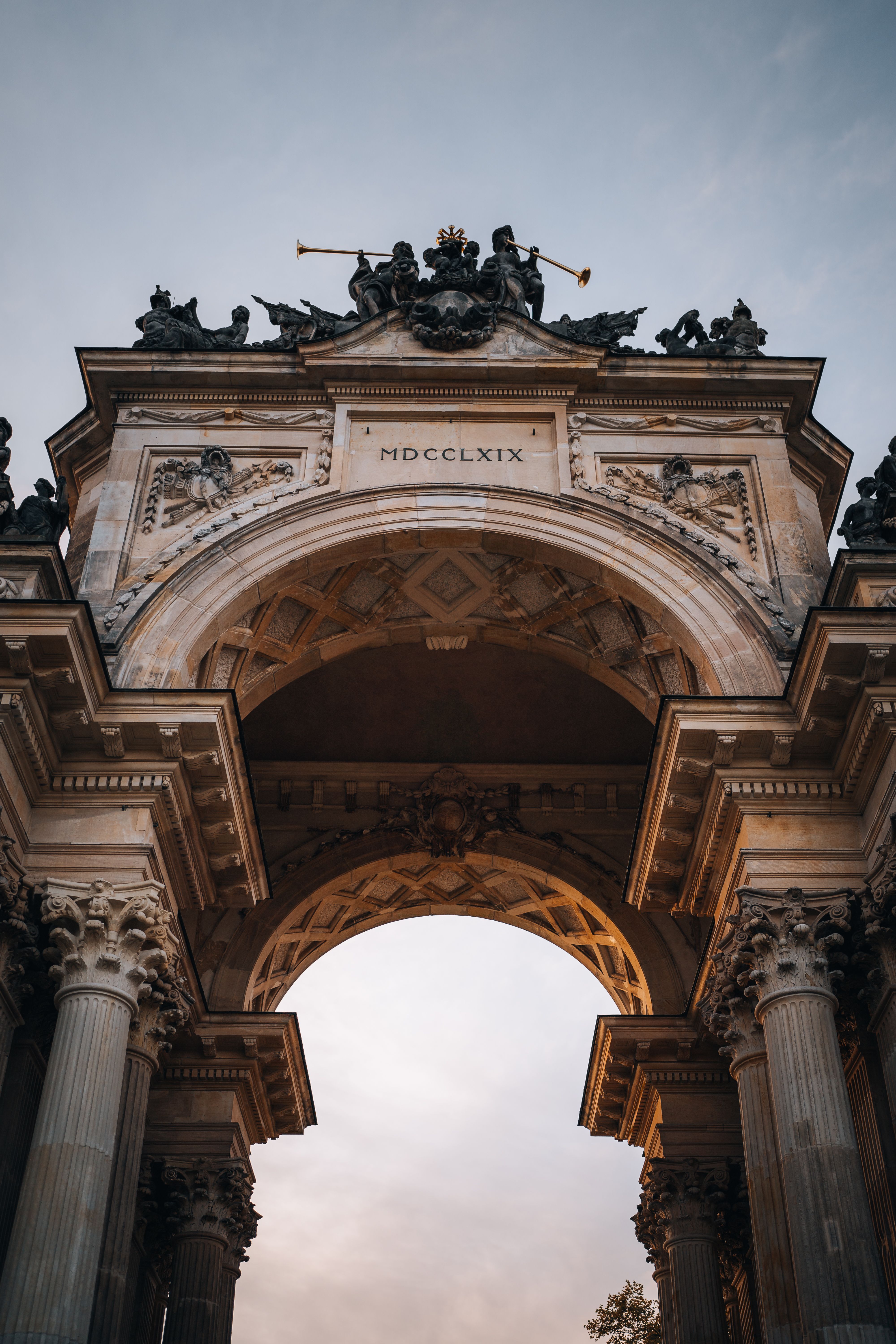 The arch of the entrance to a building with statues · Free Stock Photo
