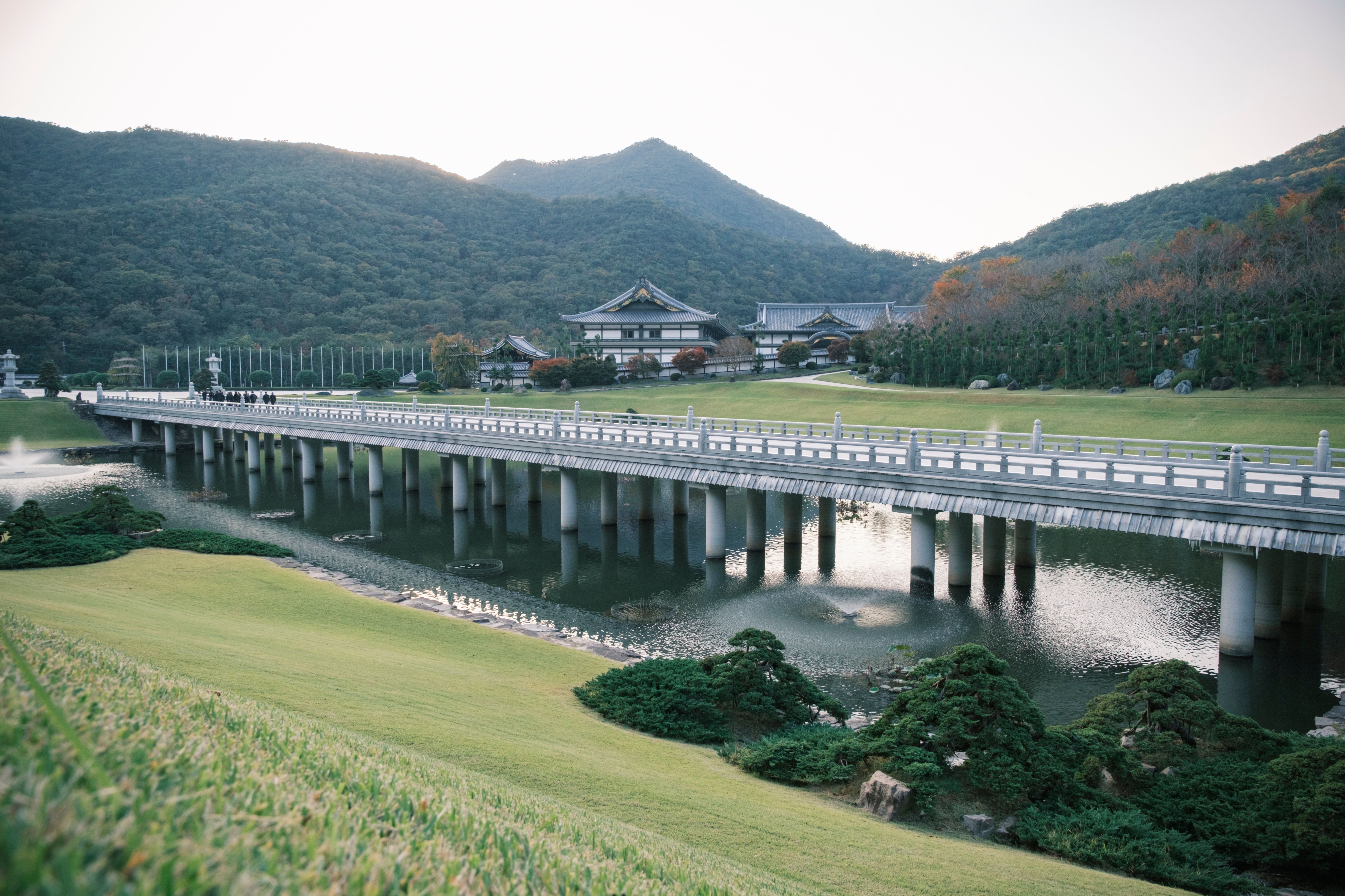Bridge in Village with Forest on Hills around · Free Stock Photo