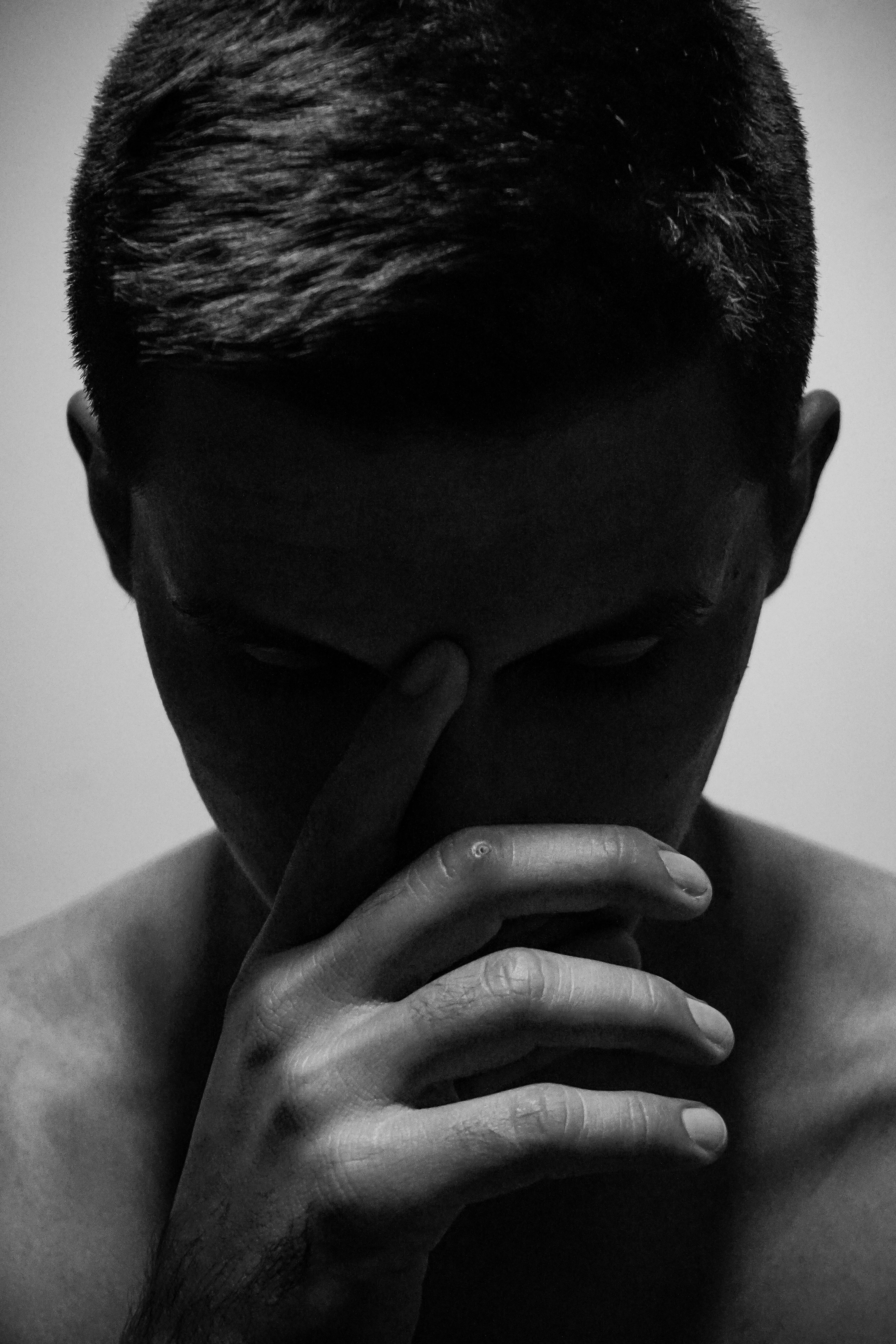 A man with his hand over his face · Free Stock Photo