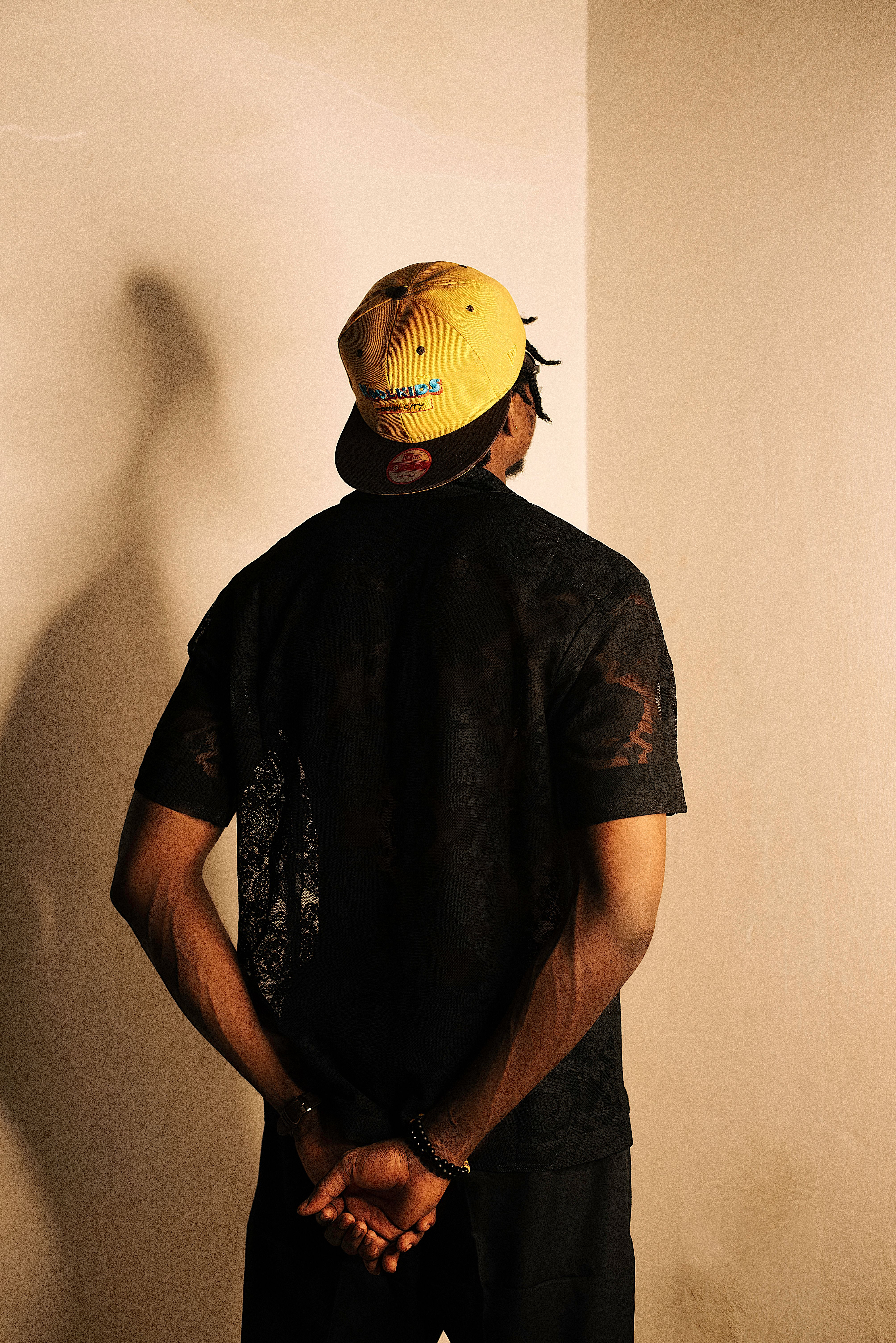 Back View of Man in Cap Standing in Corner · Free Stock Photo