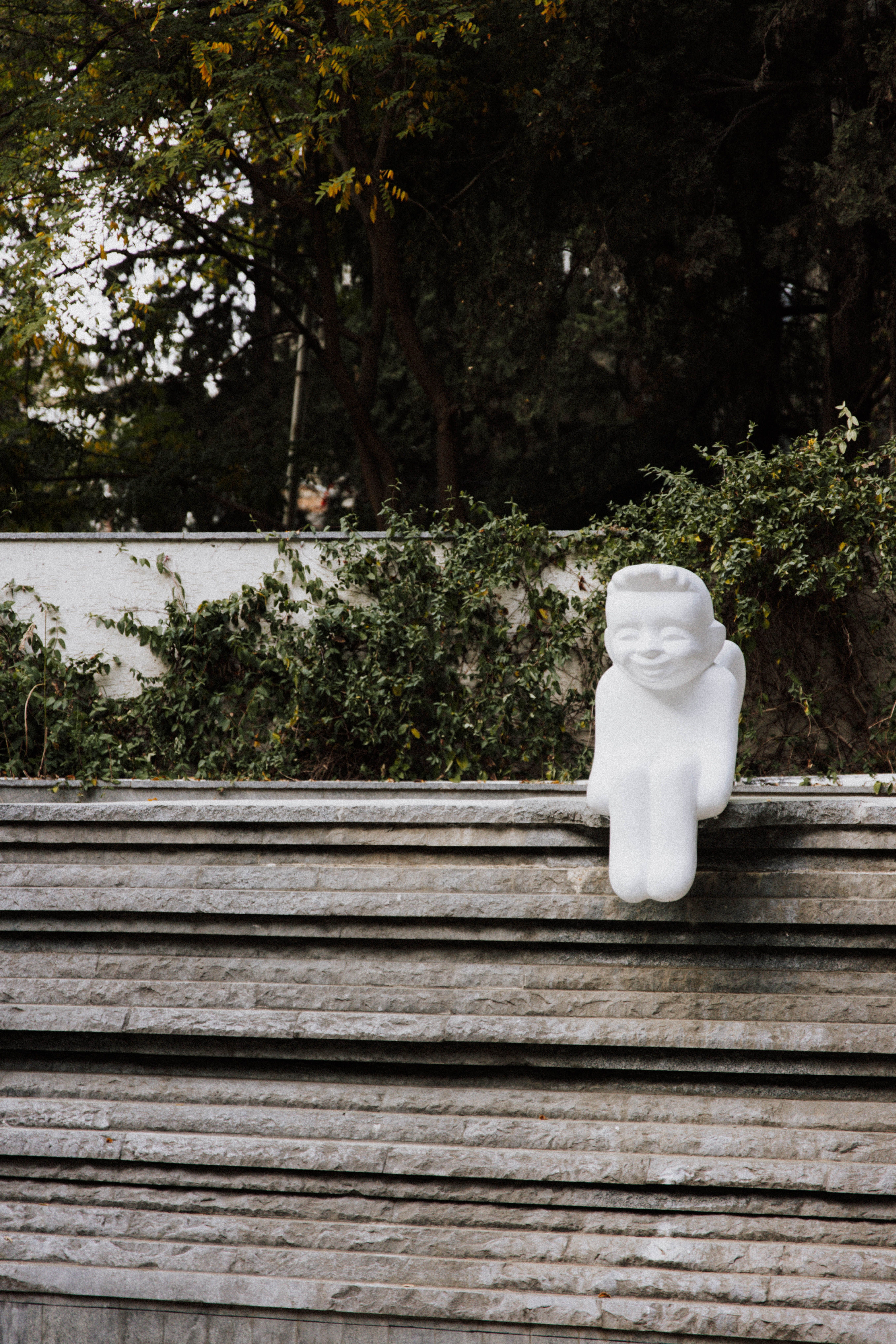 Figure of White Angel Sitting on Steps · Free Stock Photo
