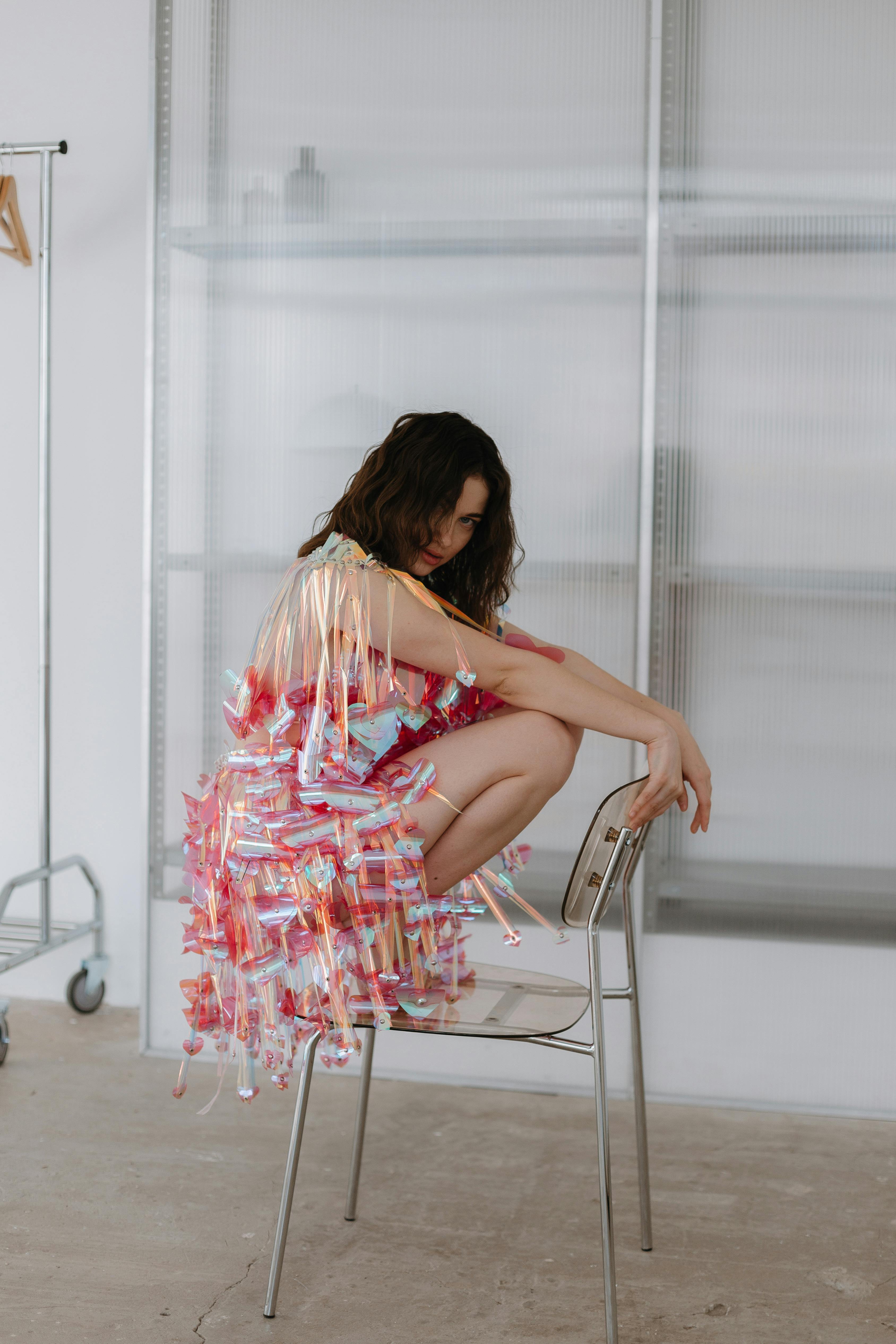 Woman in Pink Futuristic Dress Crouching on Chair · Free Stock Photo