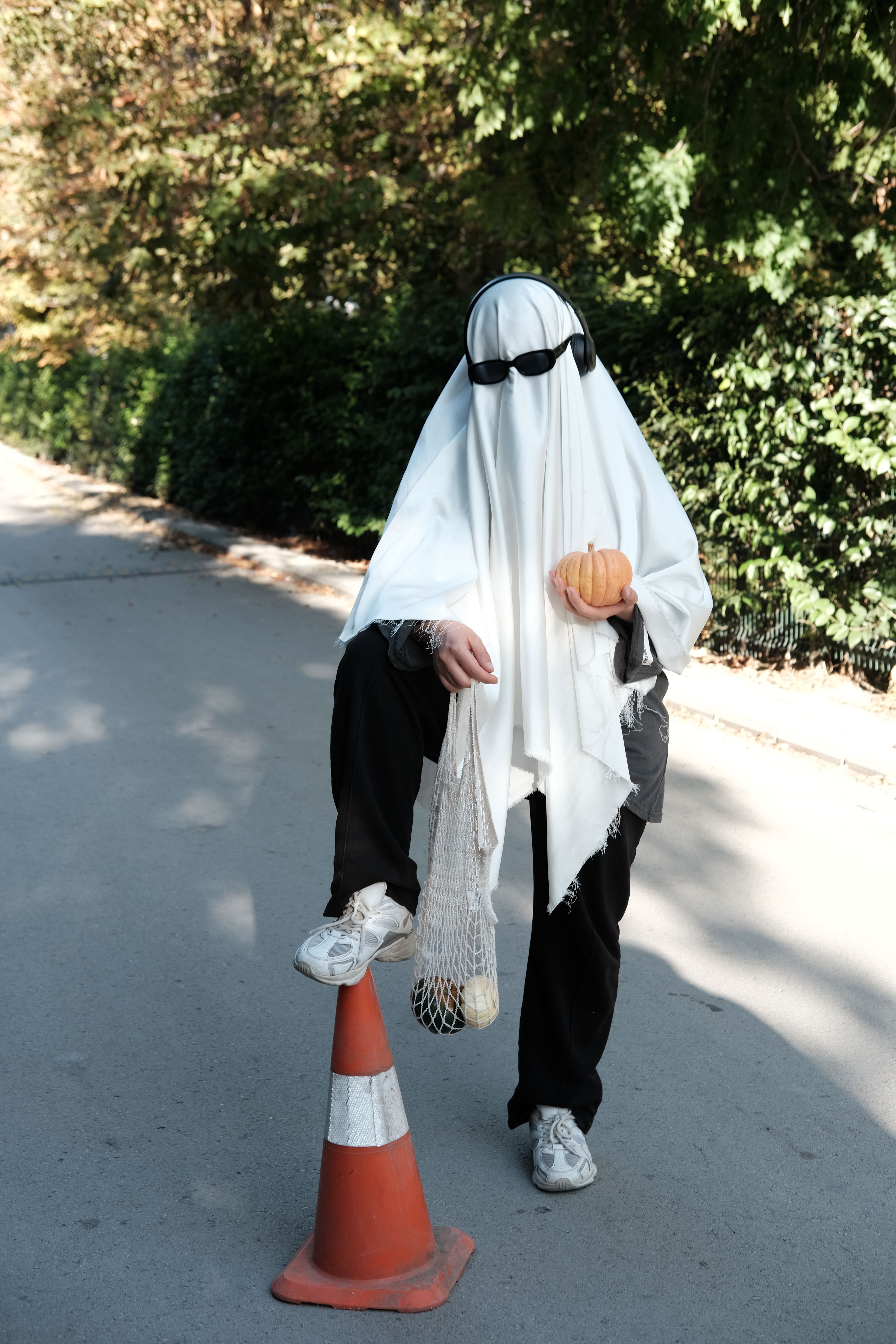 Person in Ghost Costume with Pumpkin and Shopping Bag · Free Stock Photo