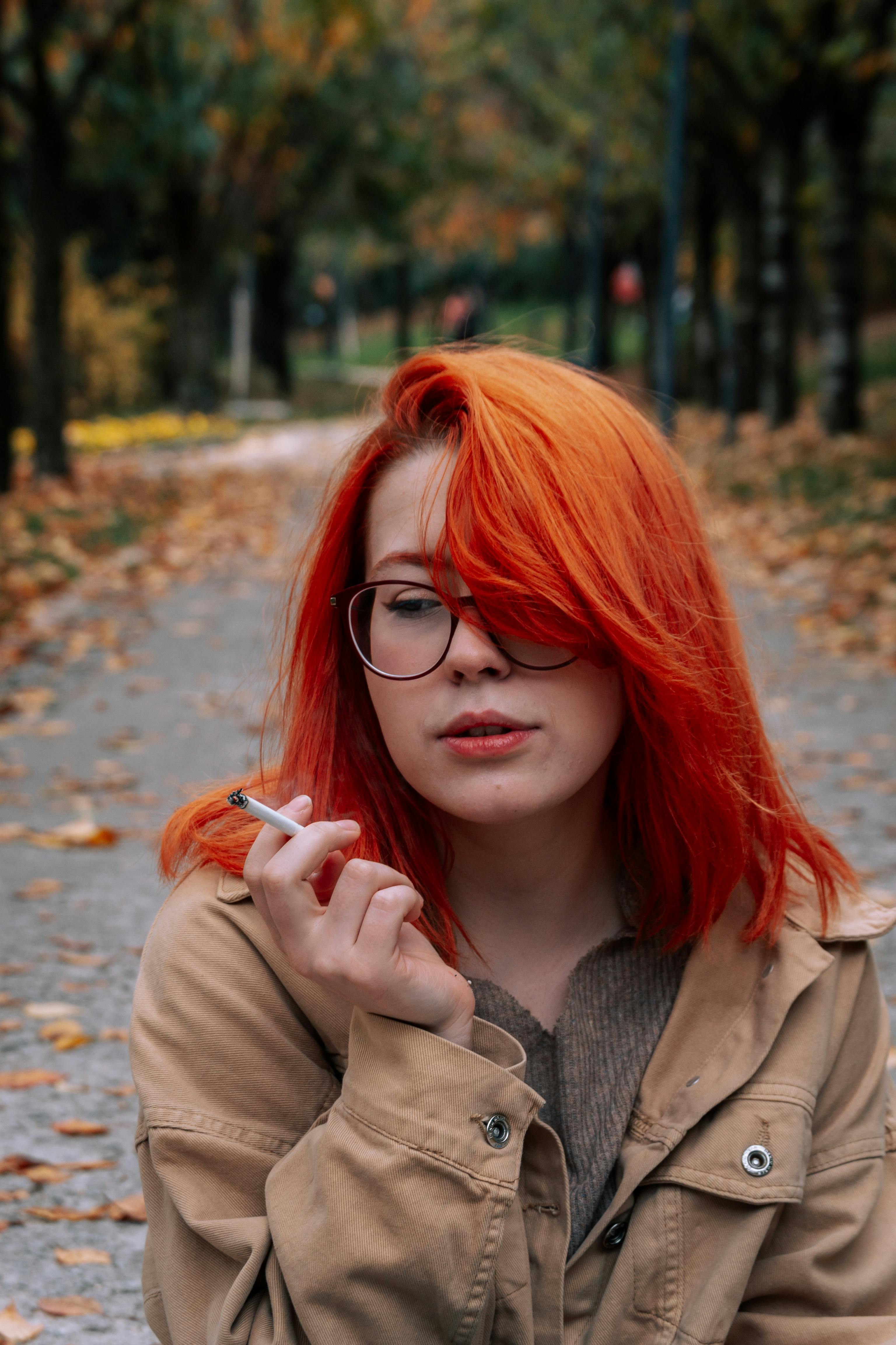 Red Haired Woman Smoking Cigarette in Park · Free Stock Photo