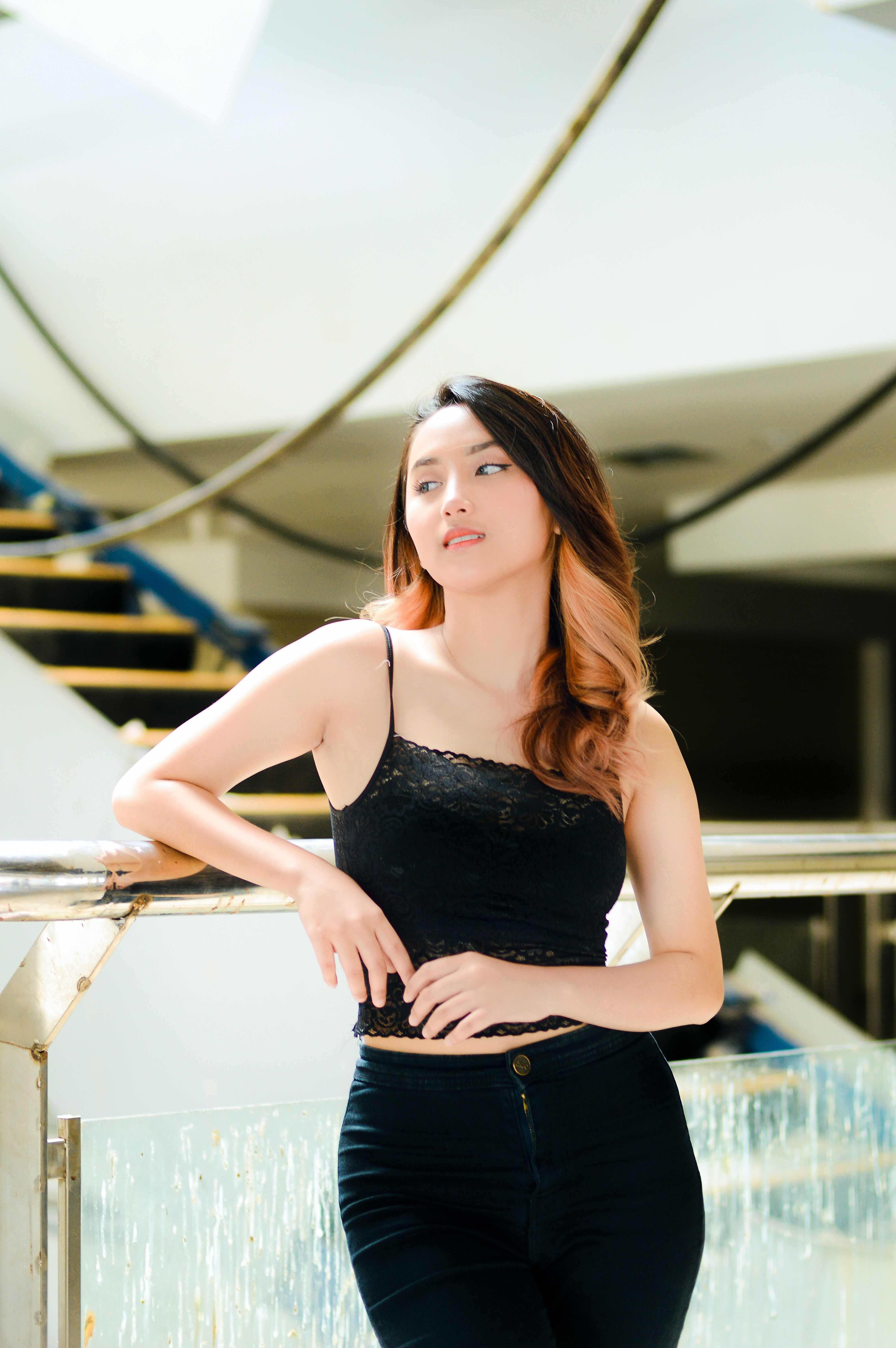 Pretty Woman in Black Top Posing by Railing · Free Stock Photo