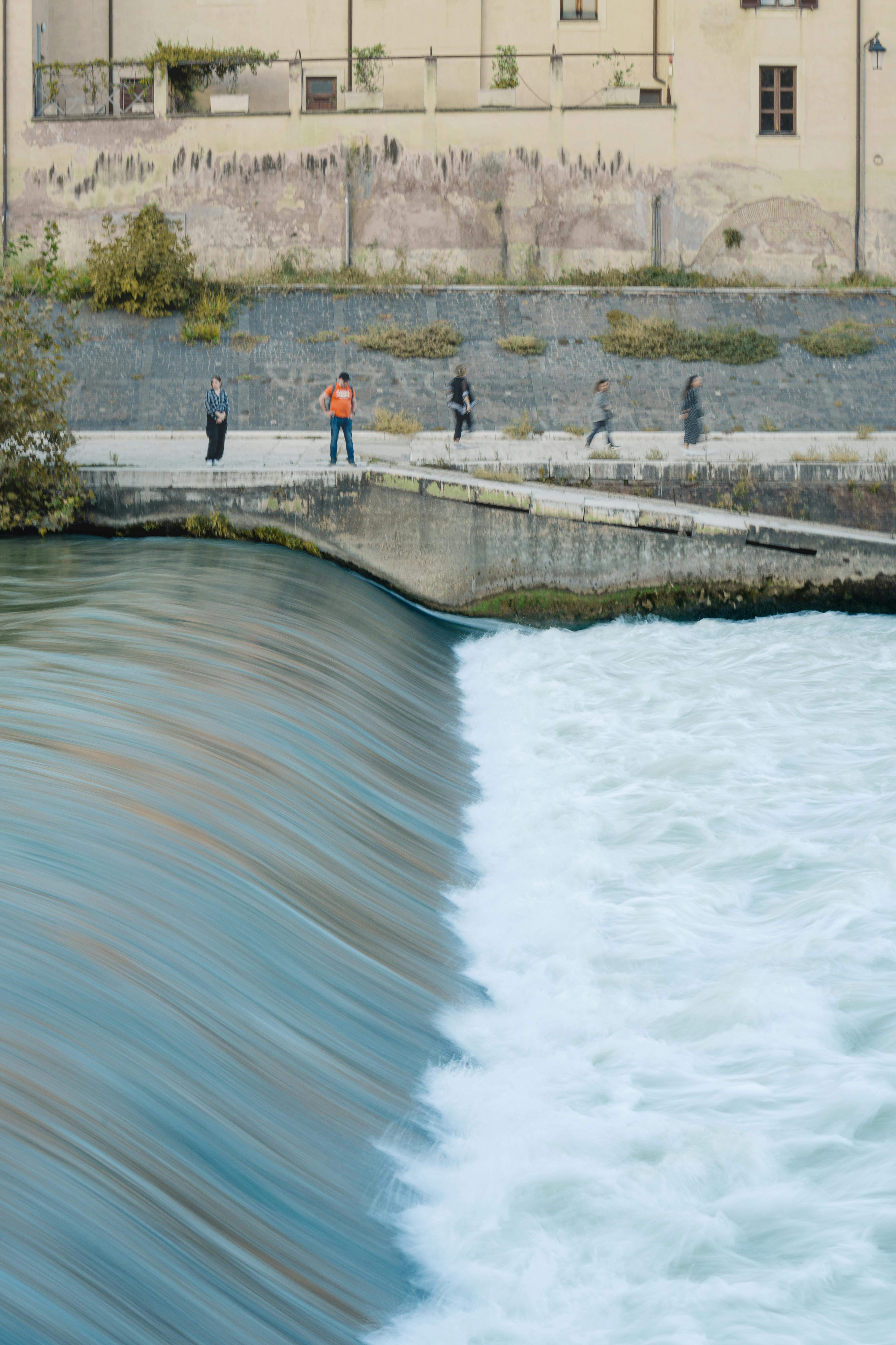 A man is walking on the side of a river · Free Stock Photo