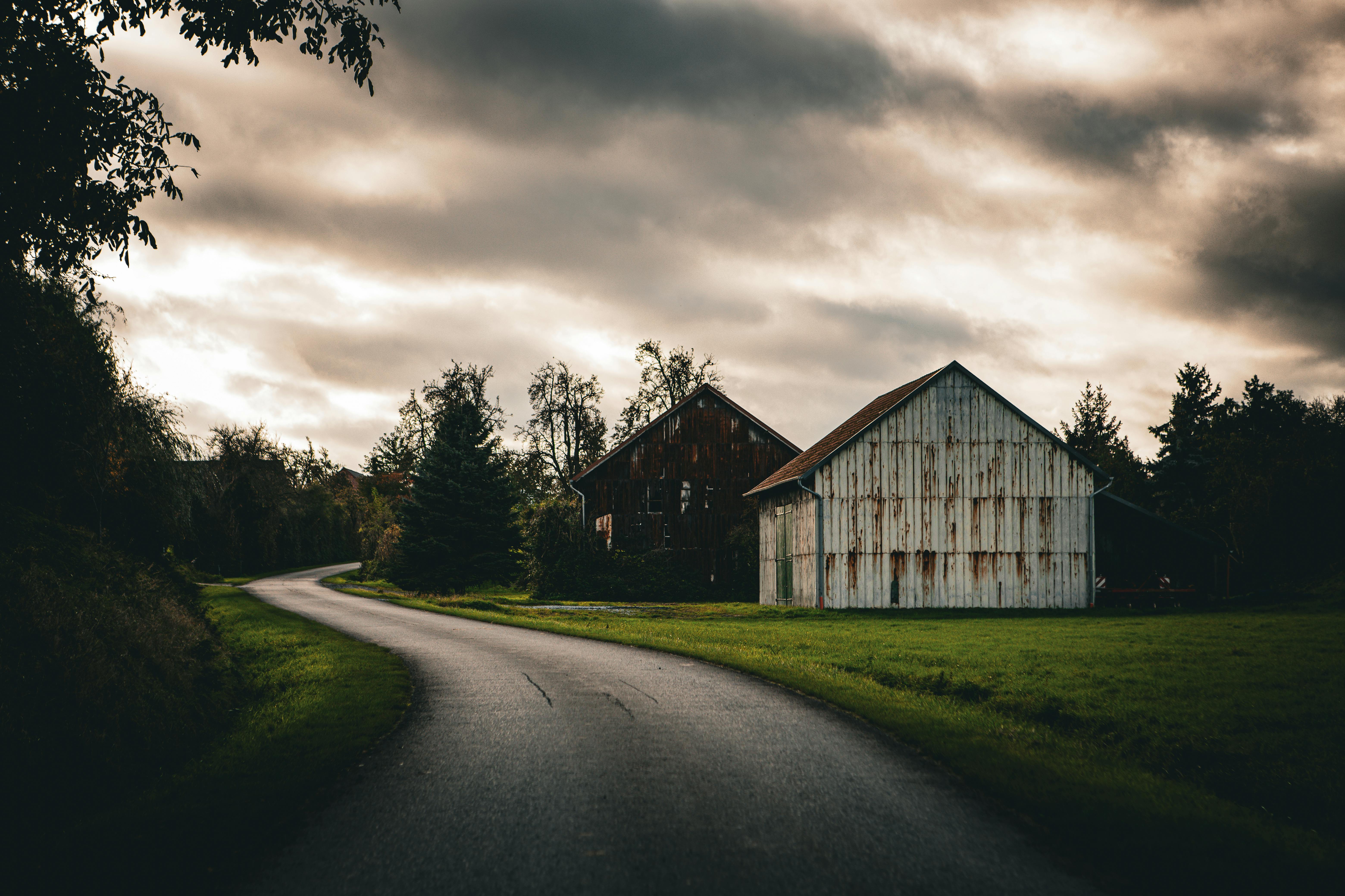 Rural Panorama with a Road Leading Past a Farm House and Barn at Dusk ...
