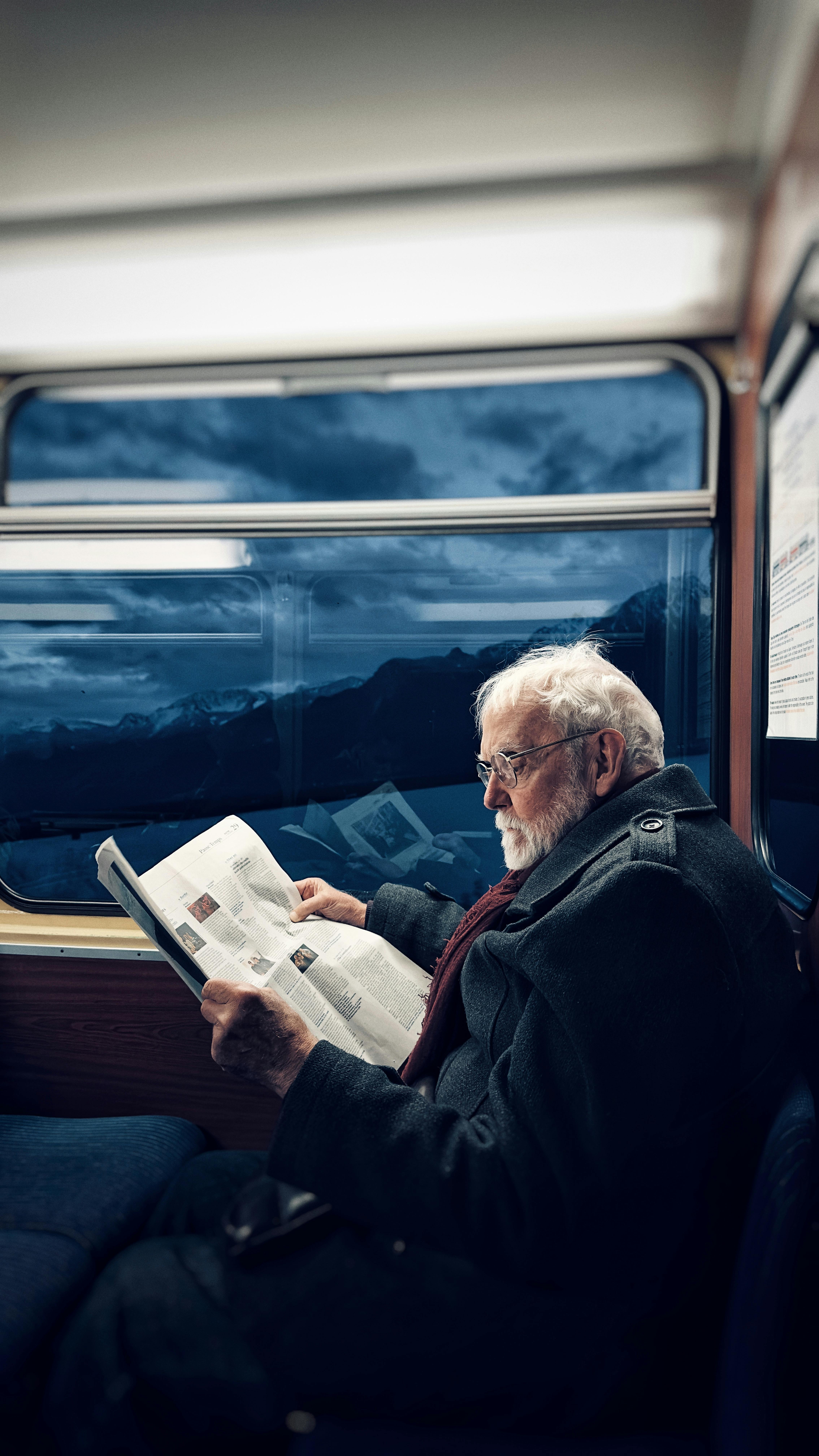 Old Bearded Man Reading Newspaper in Public Transport · Free Stock Photo