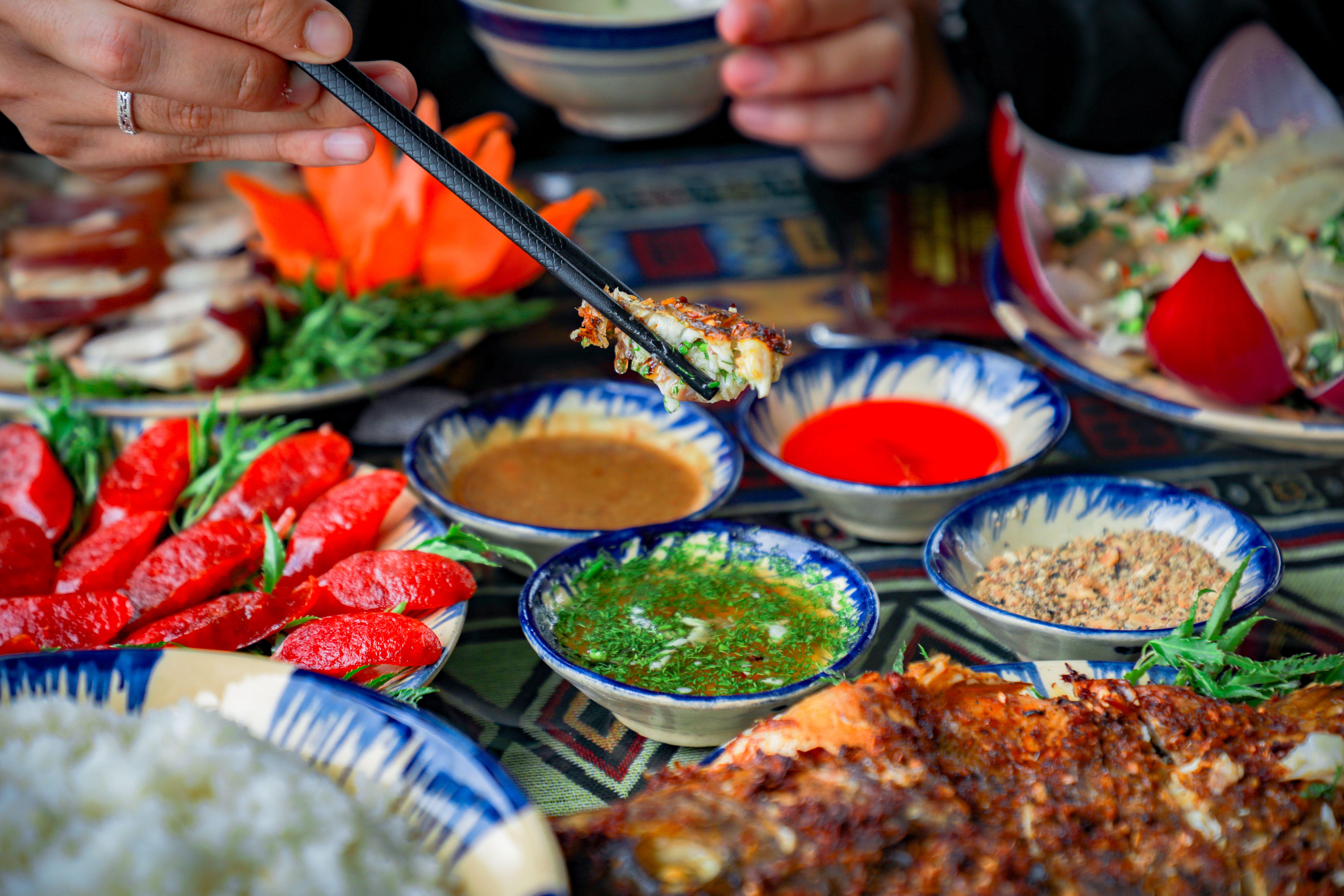 Close-up of a Person Grabbing Food from the Table with Chopsticks ...