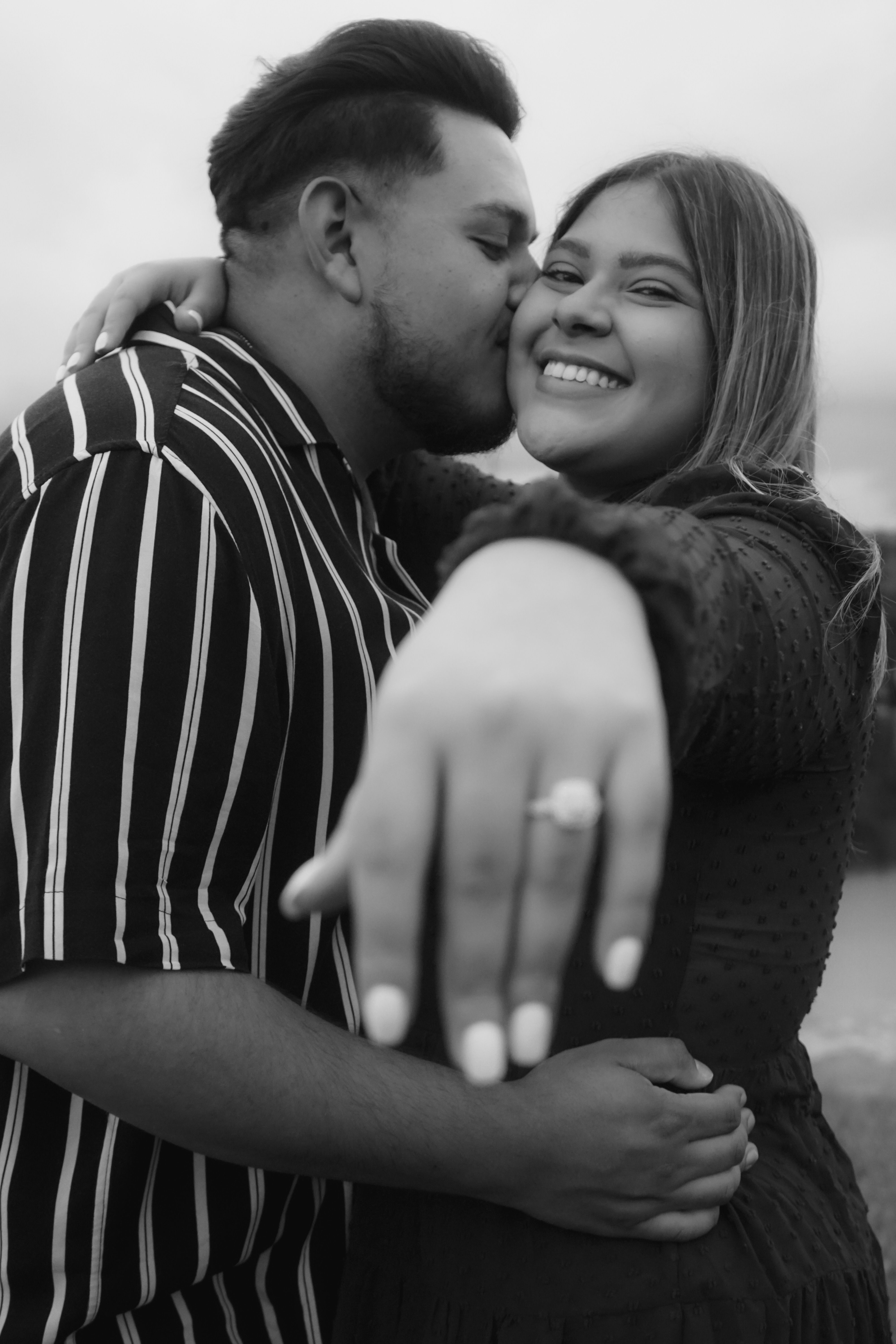 Woman Showing Her Engagement Ring and Man Kissing Her on the Cheek ...