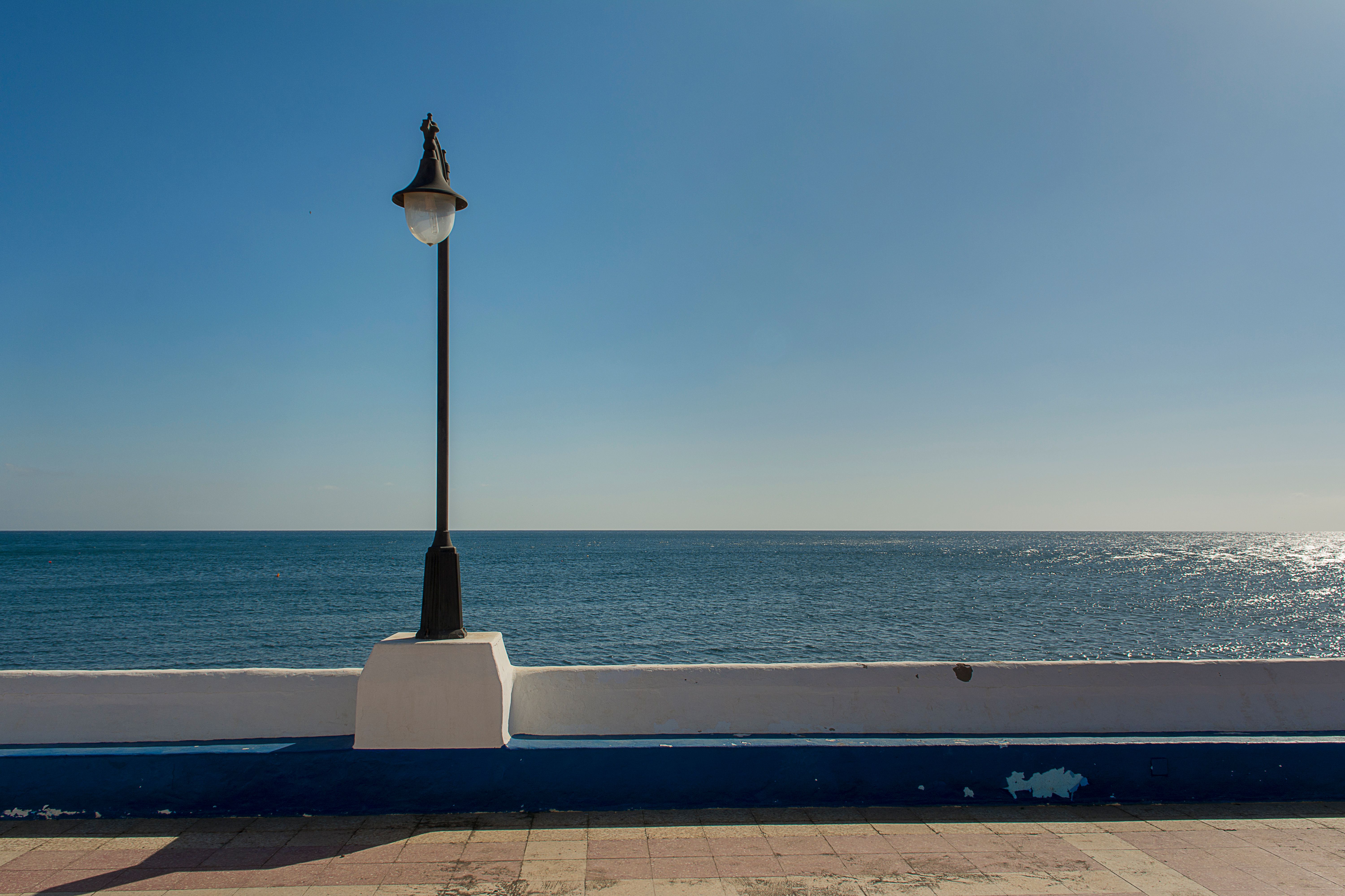 A Lantern on a Pier with the View of the Sea · Free Stock Photo