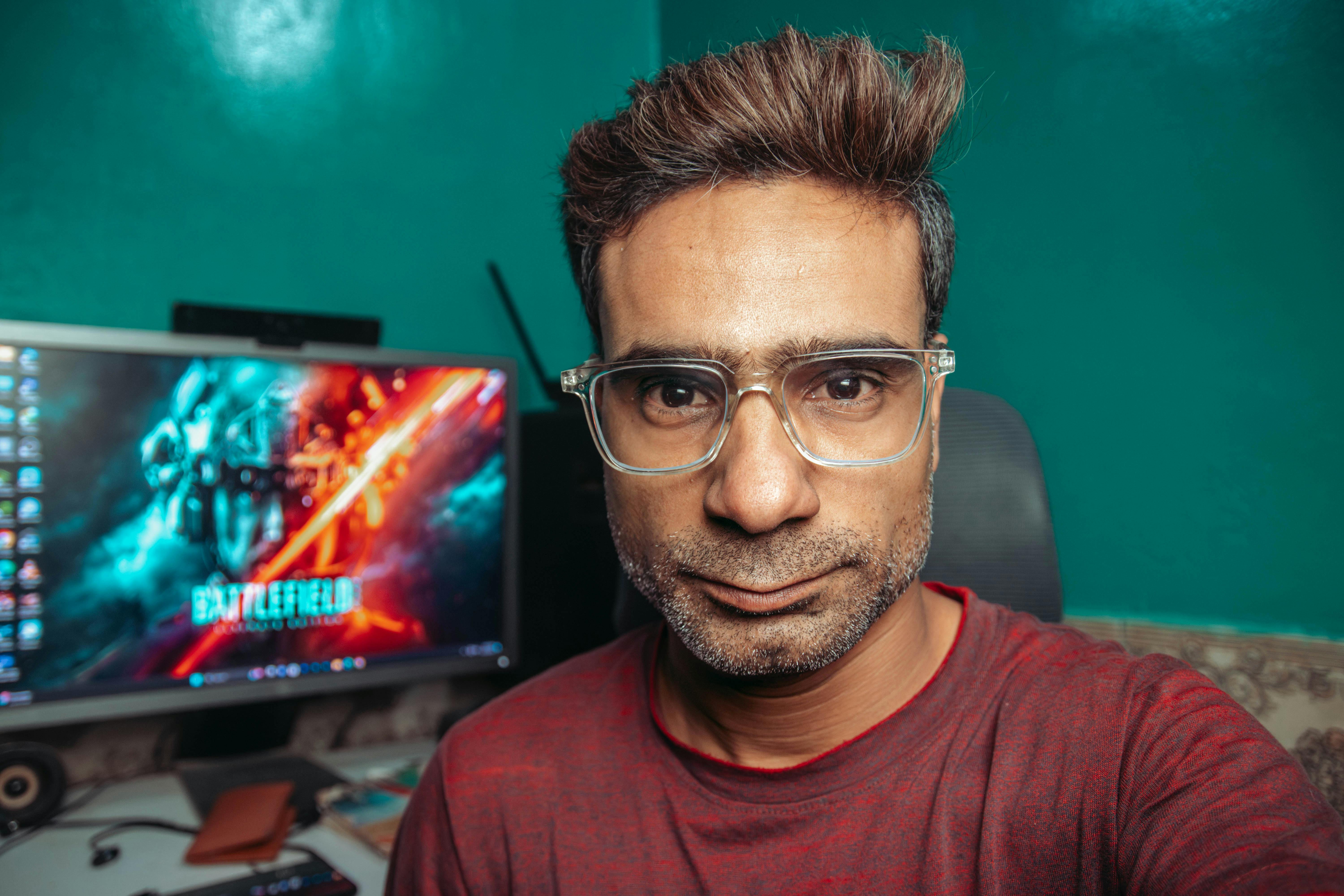 Man in Eyeglasses with Monitor behind · Free Stock Photo