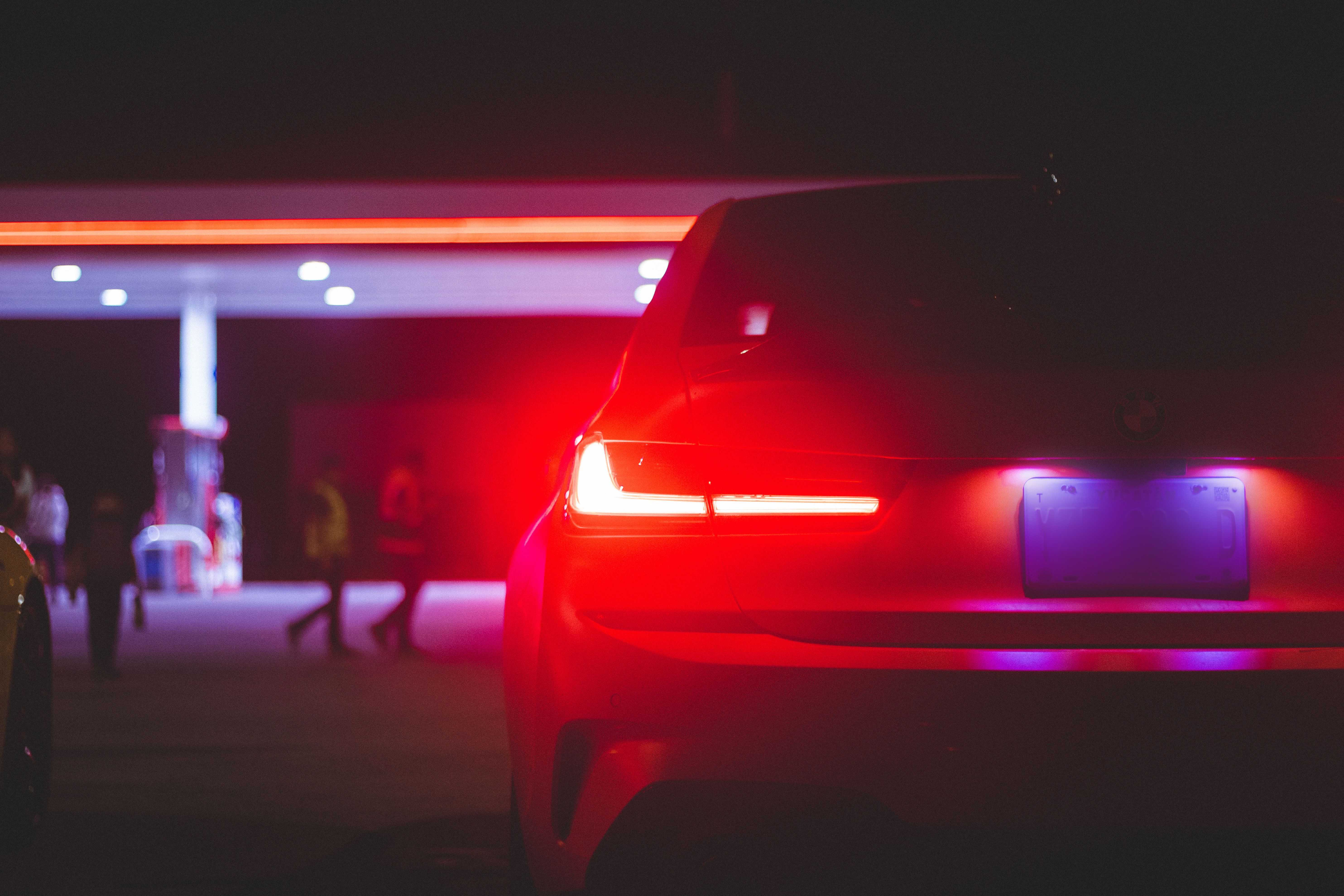 A car is lit up at night with a red light · Free Stock Photo