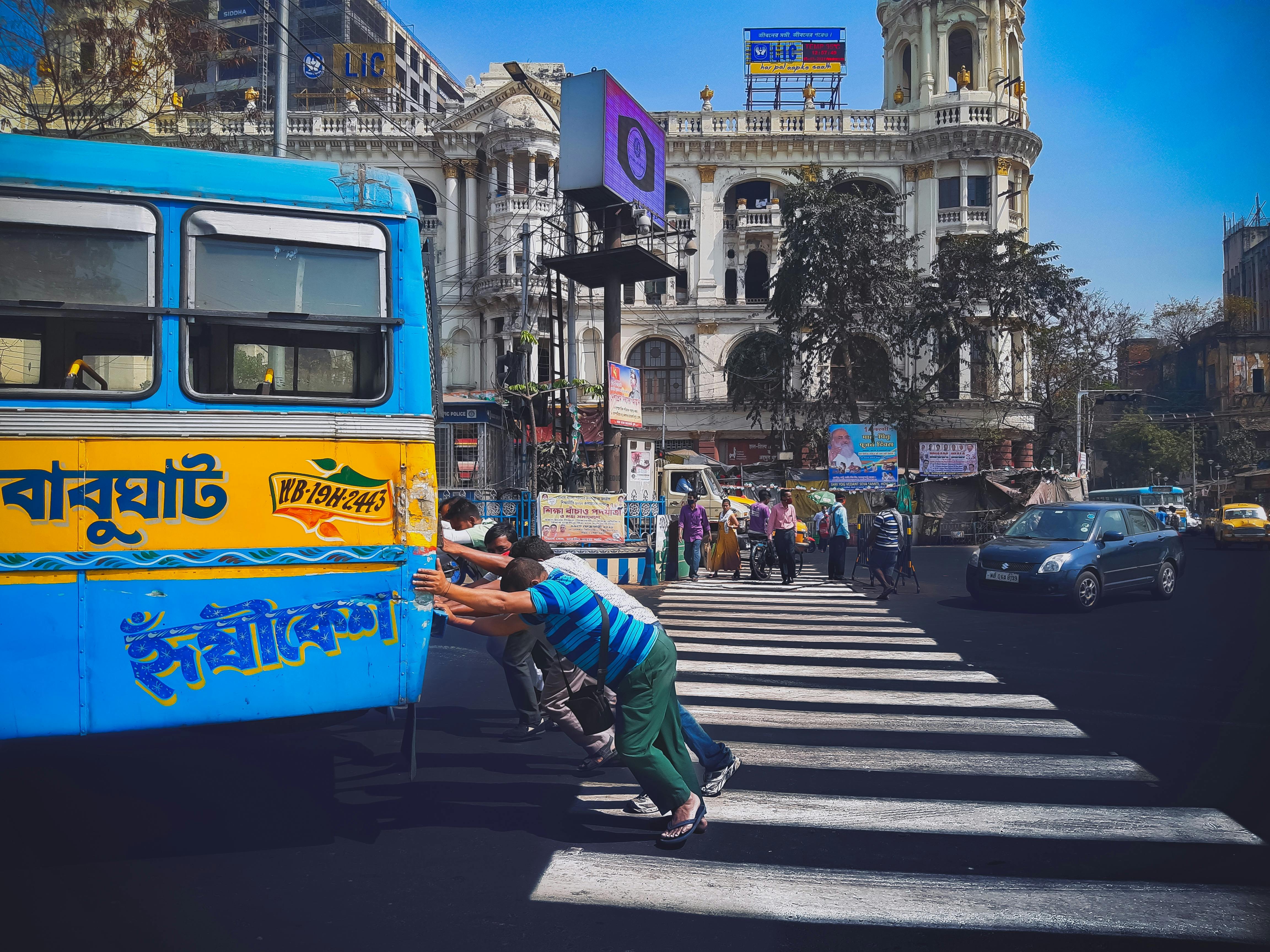 People Pushing Bus on Street in Kolkata · Free Stock Photo