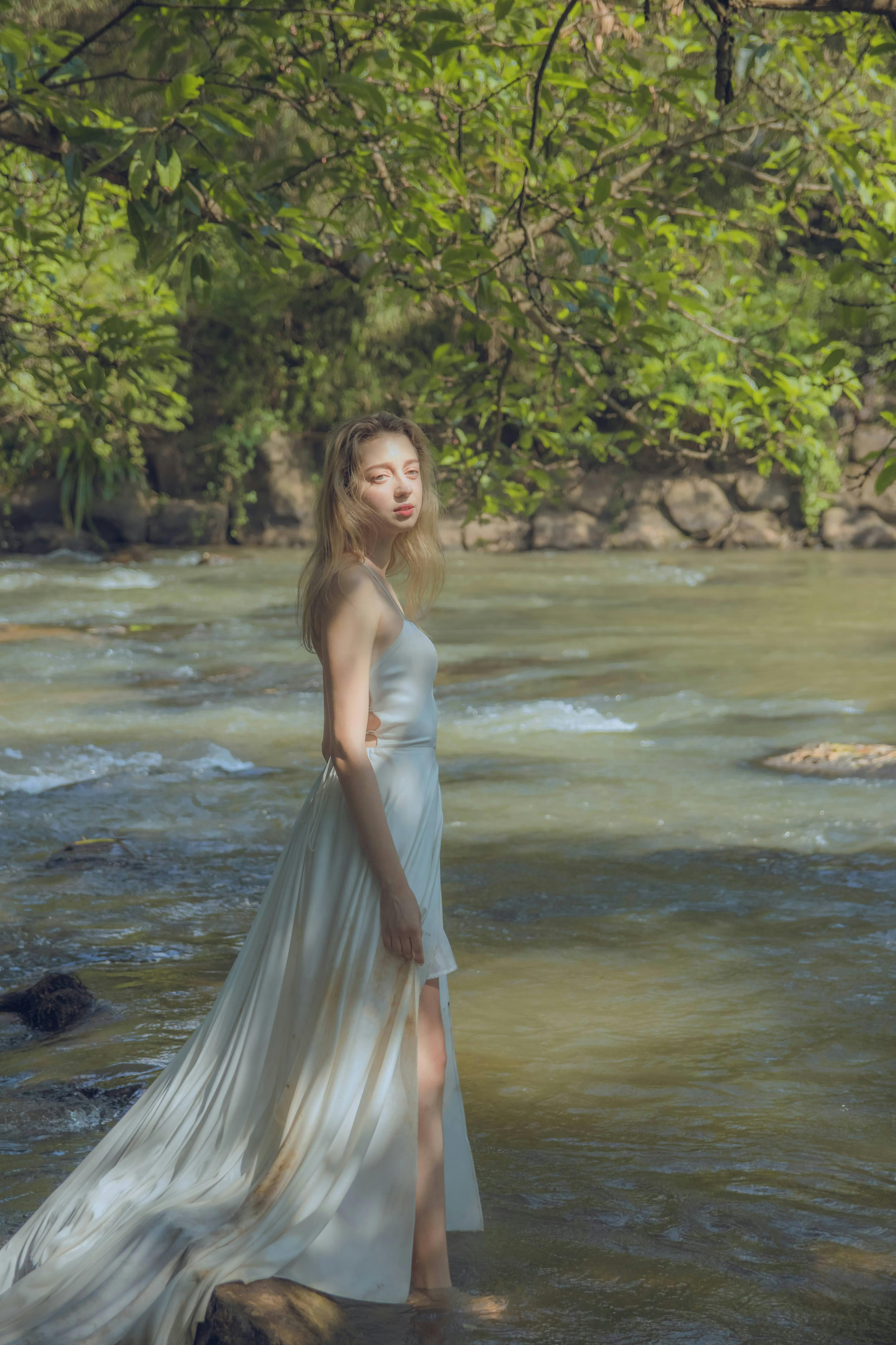 Woman in Red String Spaghetti Strap Dress on Body of Water Near Forest ...