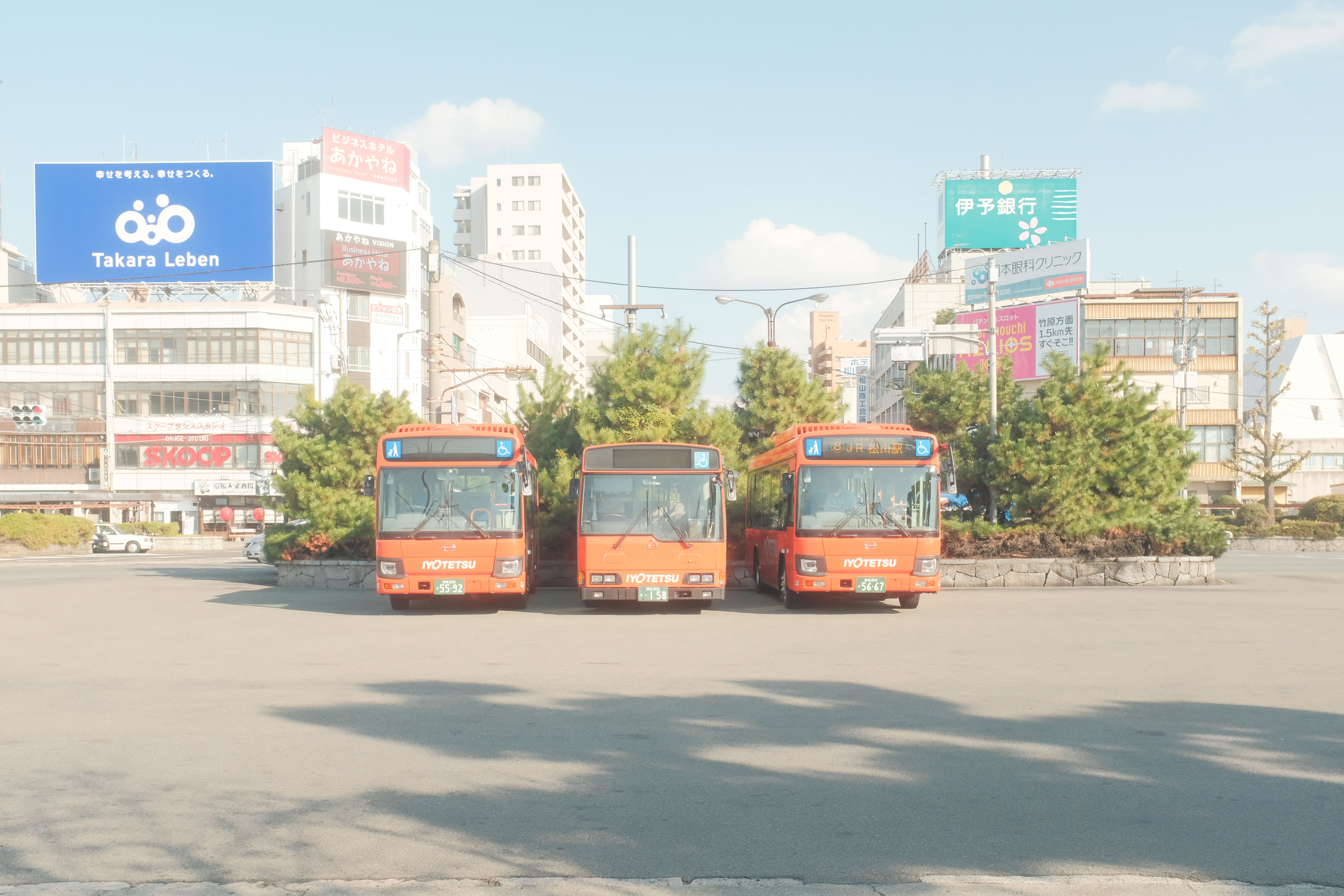 Orange Buses Parked on a Japanese City Street · Free Stock Photo