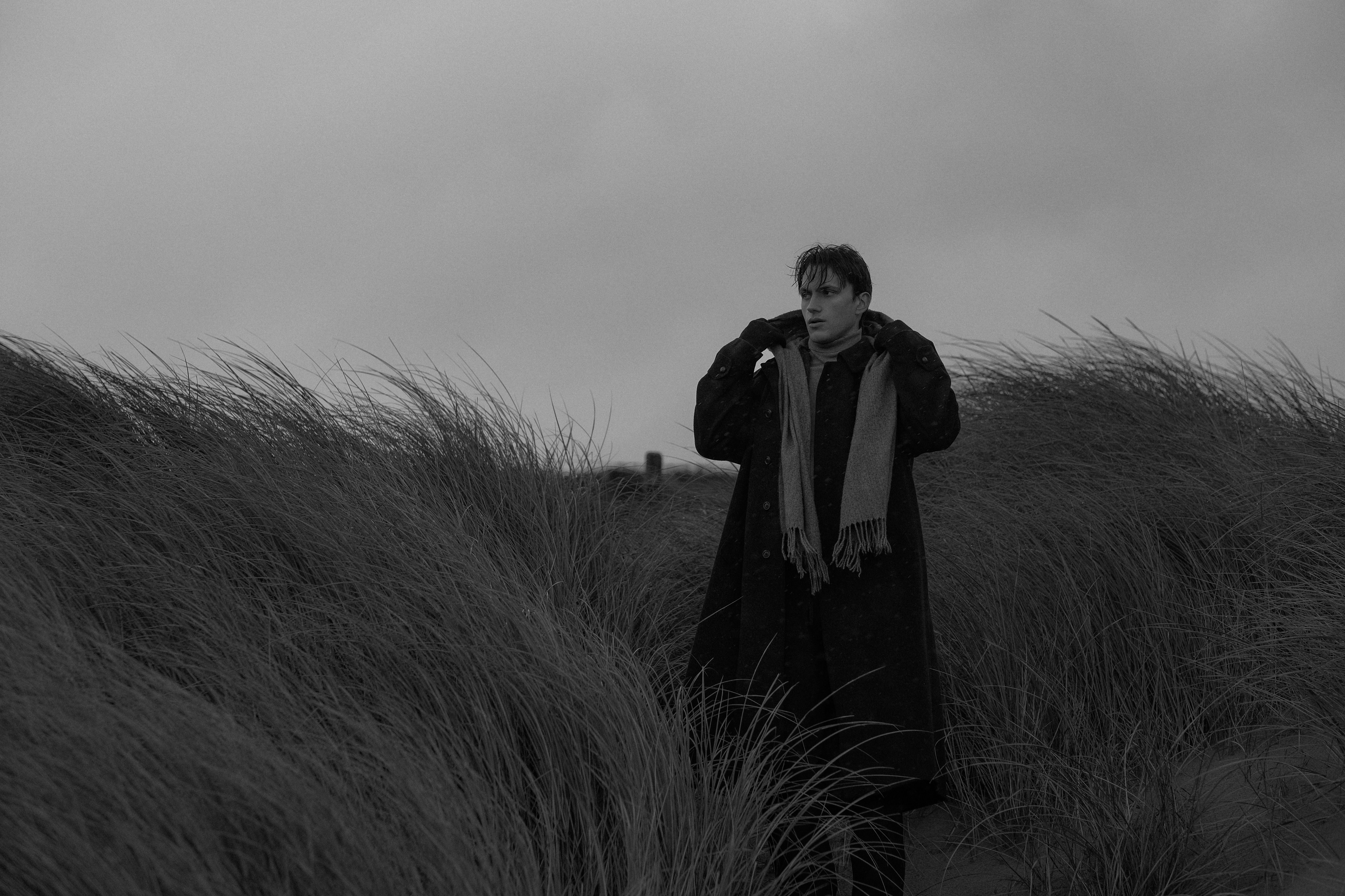 Man Wearing Coat on a Field in Black and White · Free Stock Photo