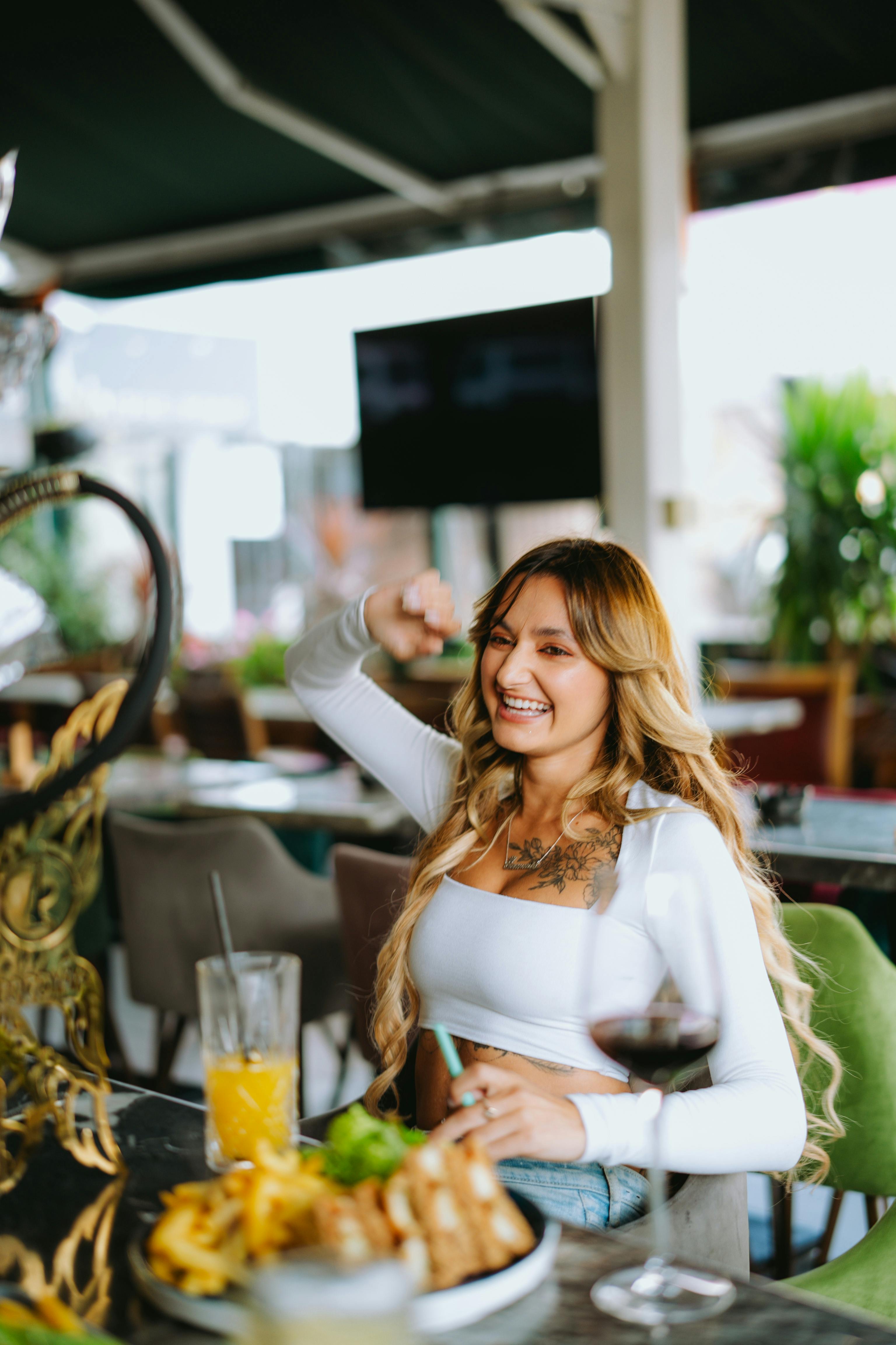 Laughing Woman at a Table in a Restaurant · Free Stock Photo