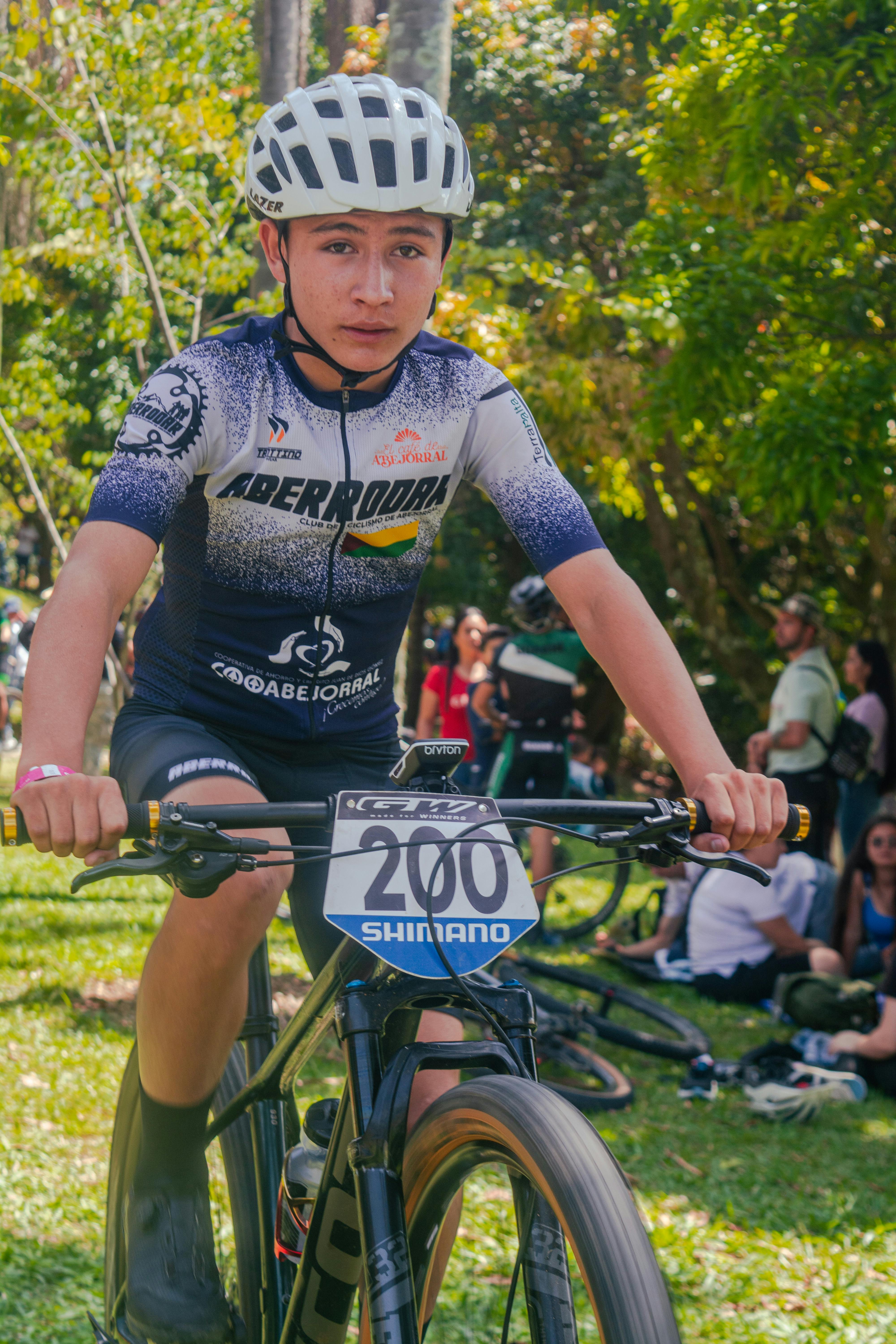 Anonymous kid in helmet riding run bike on pavement in countryside ...