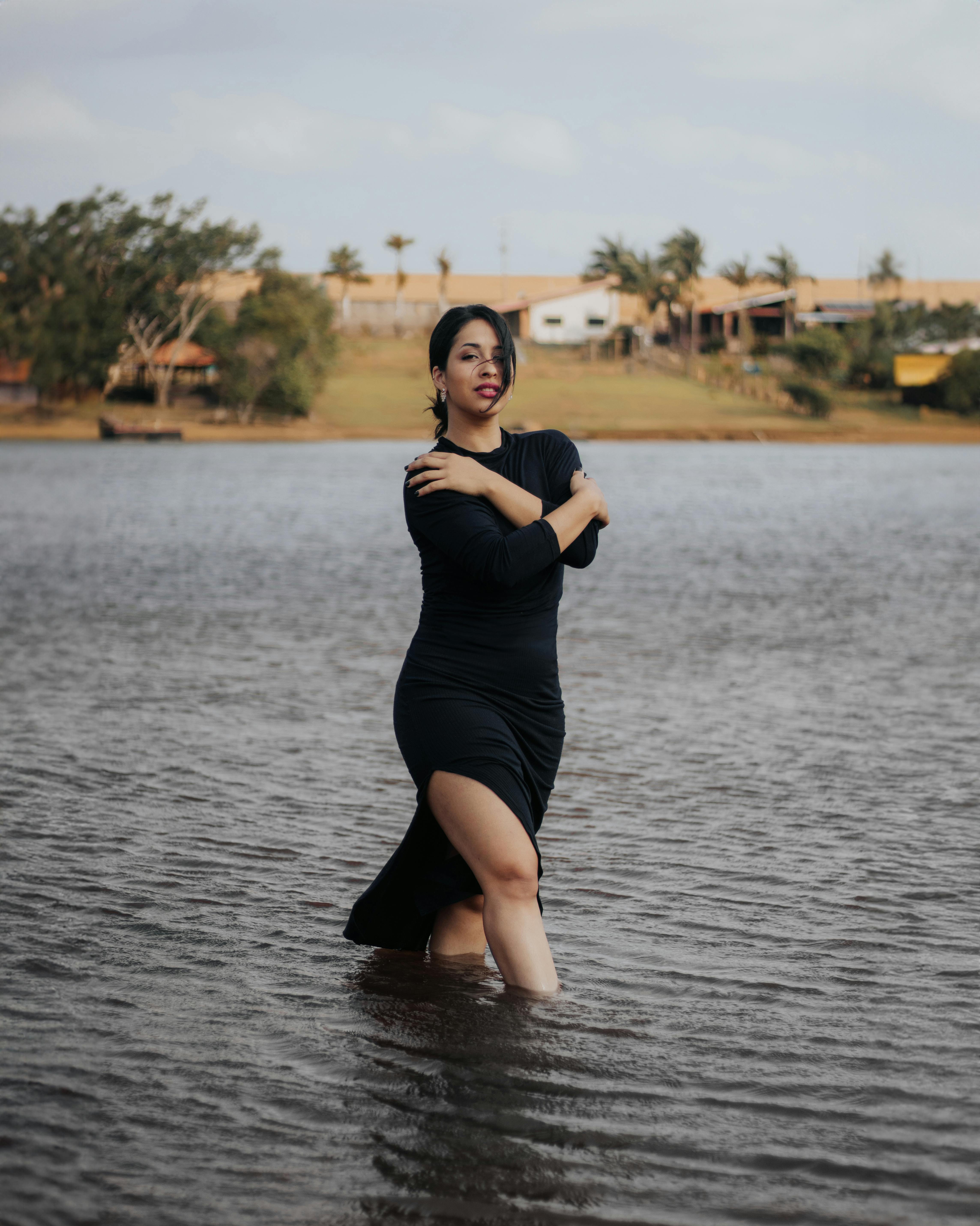 Model in a Black Dress with a Slit Wading in the River · Free Stock Photo