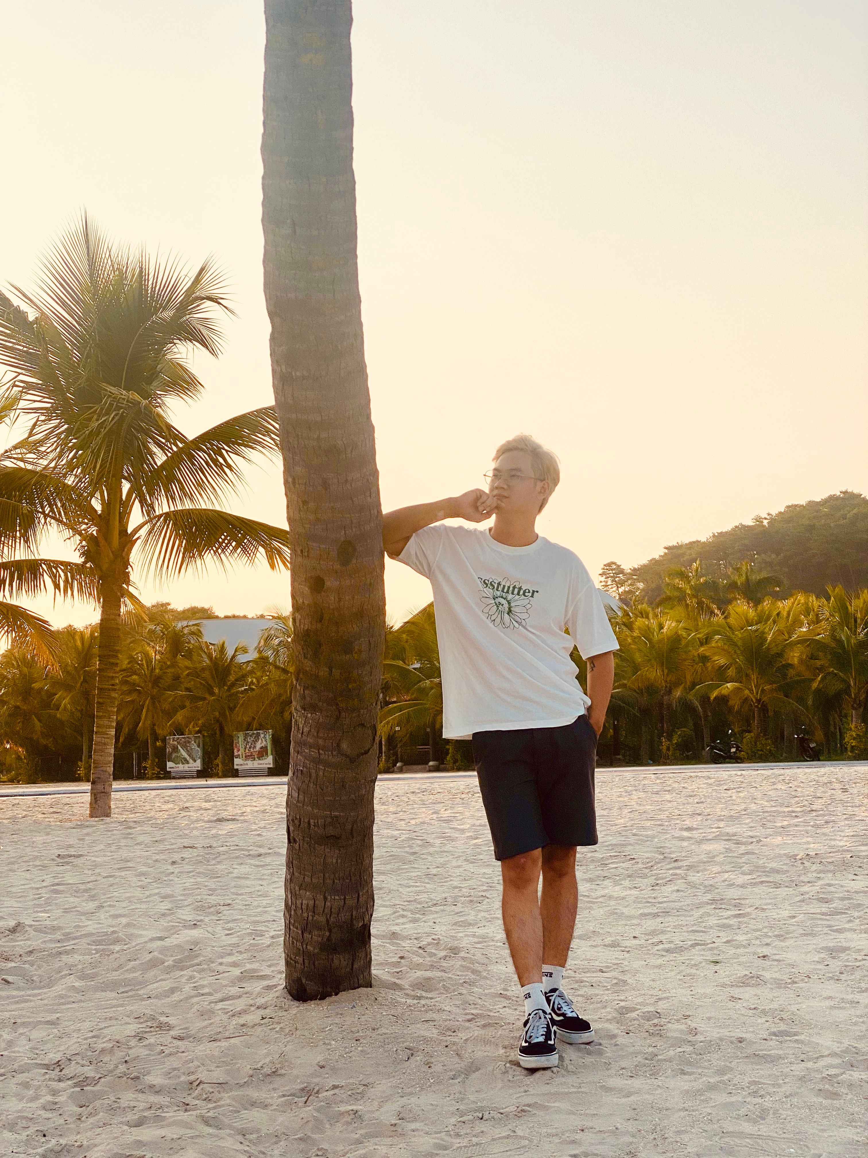 Handsome Man in White Short Posing in Front of Palm Tree · Free Stock Photo