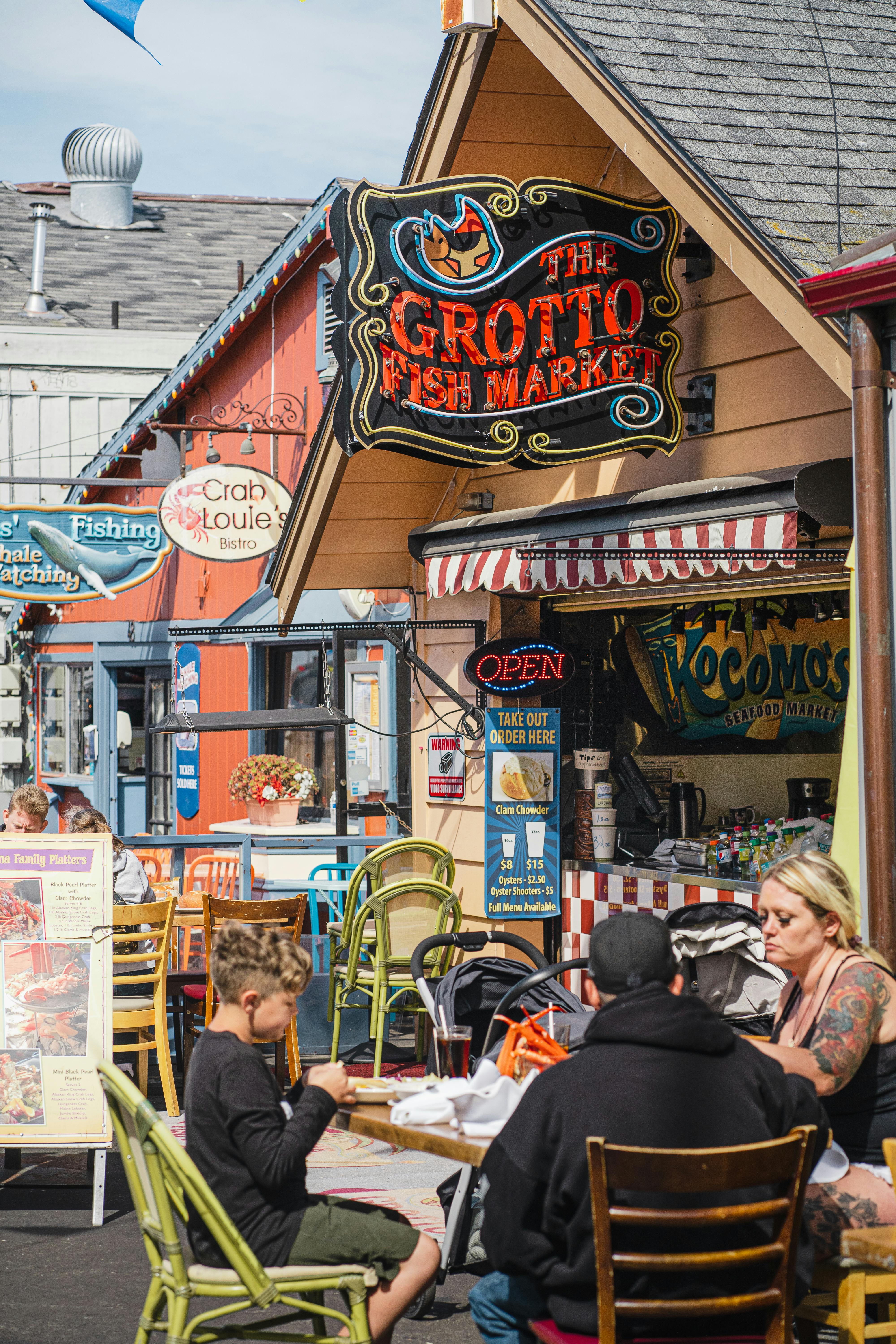 People Eating at a Table in Front of Seafood Restaurant Grotto Fish ...