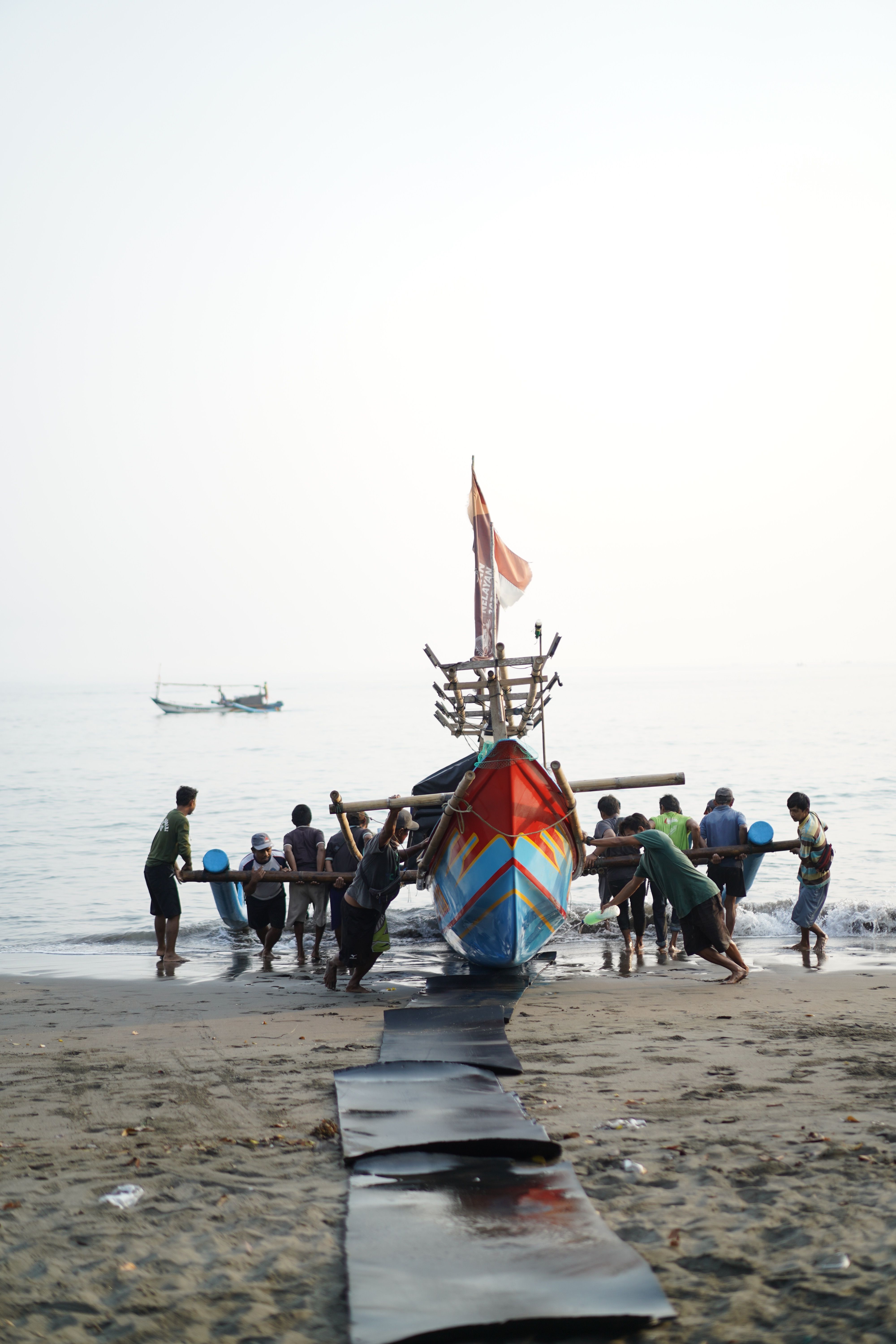 Men Pushing Boat into the Sea · Free Stock Photo