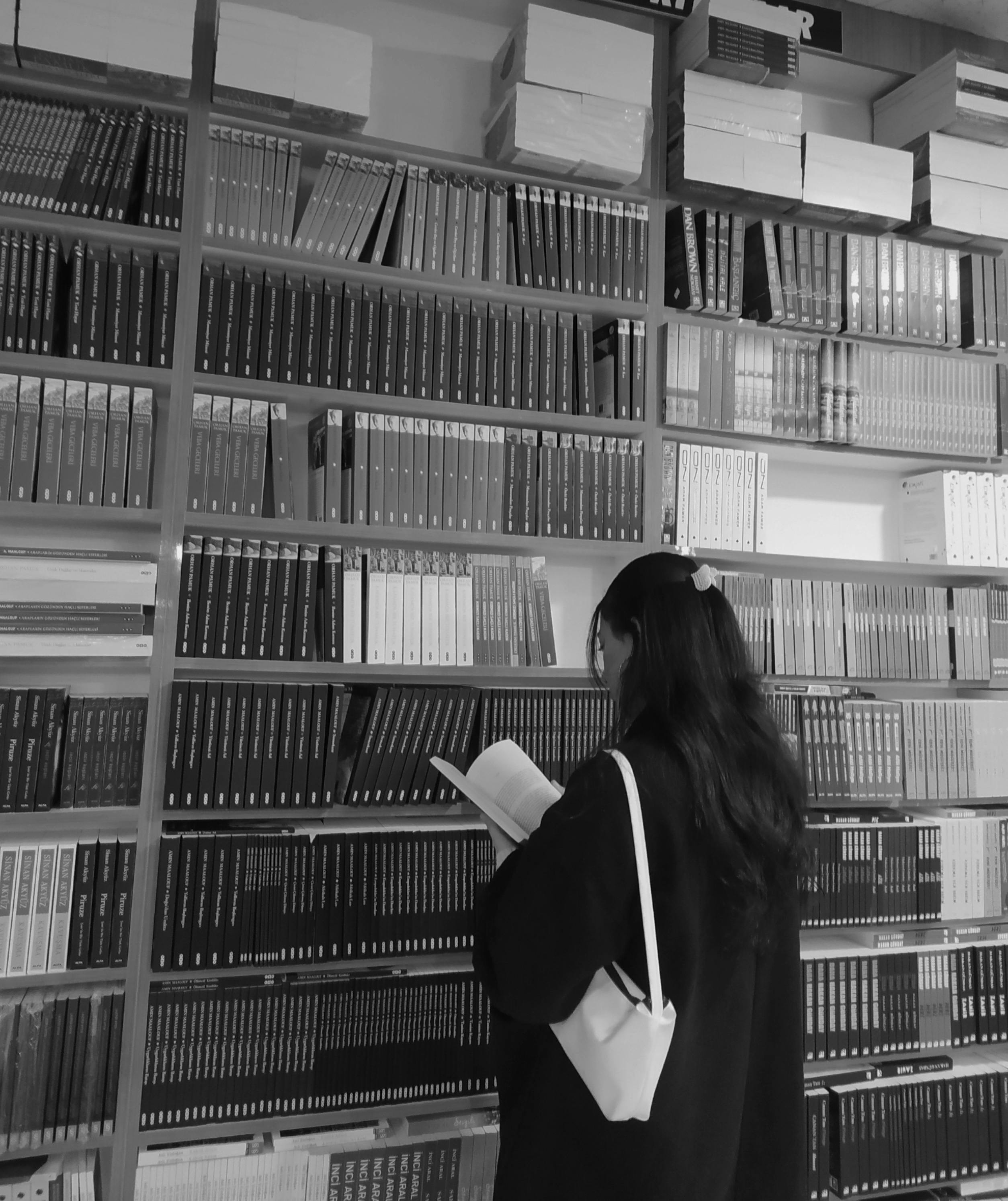 Woman Looking Through a Book in a Bookstore · Free Stock Photo